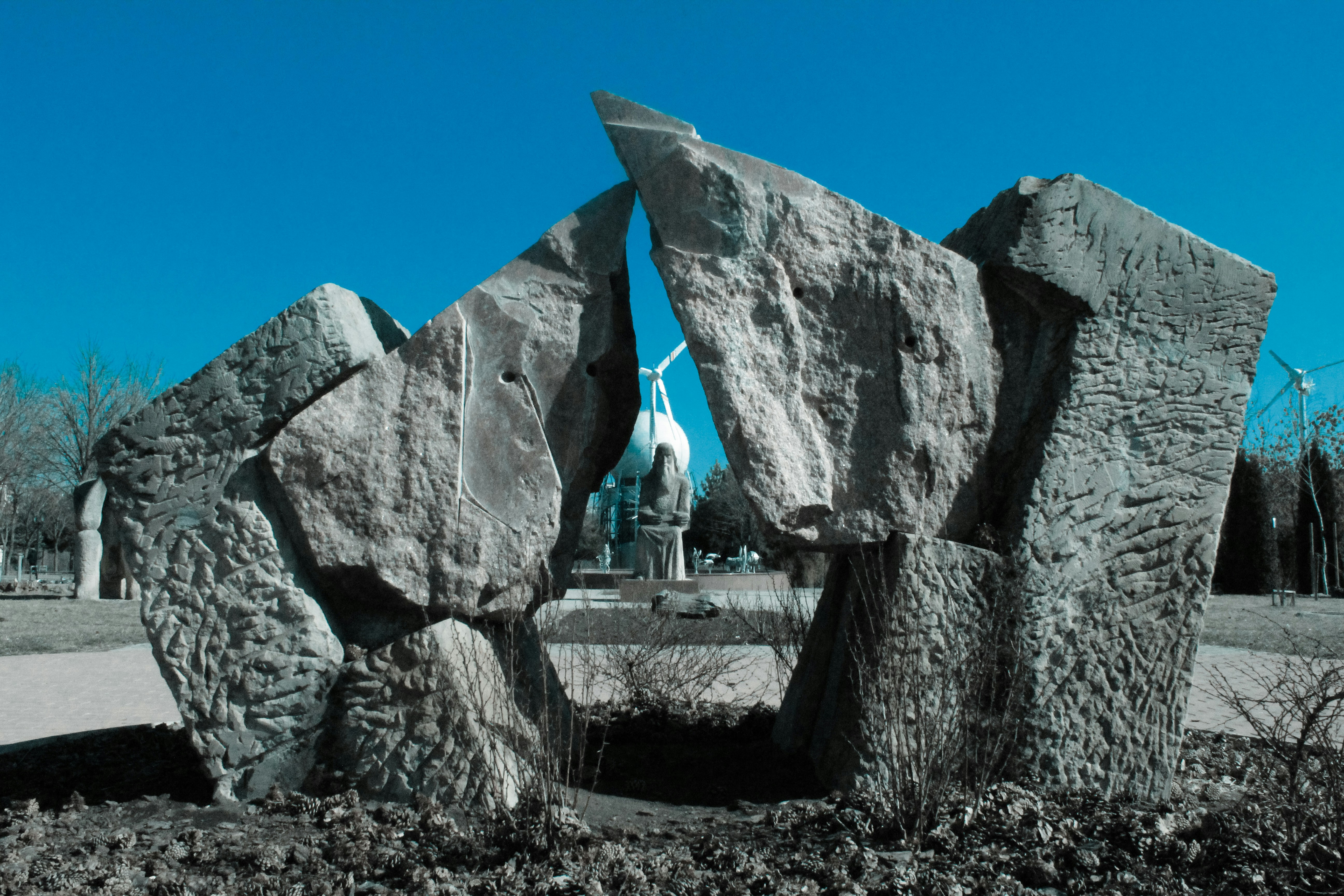 Fragmented Pillars: Stone Sculptures Framed by a Turquoise Sky