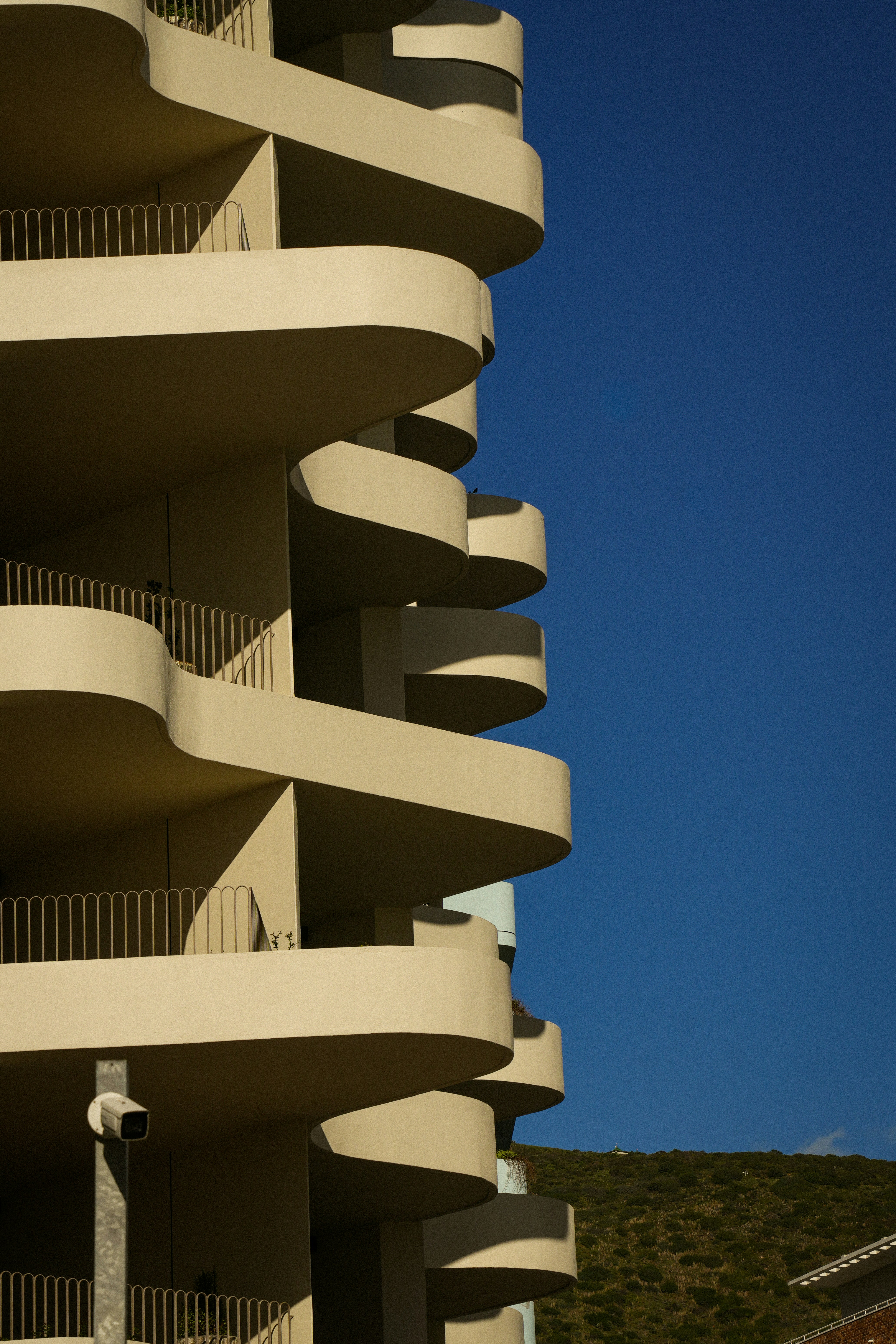 Rhythms of Concrete: A Spiral Terrace Against a Clear Blue Sky