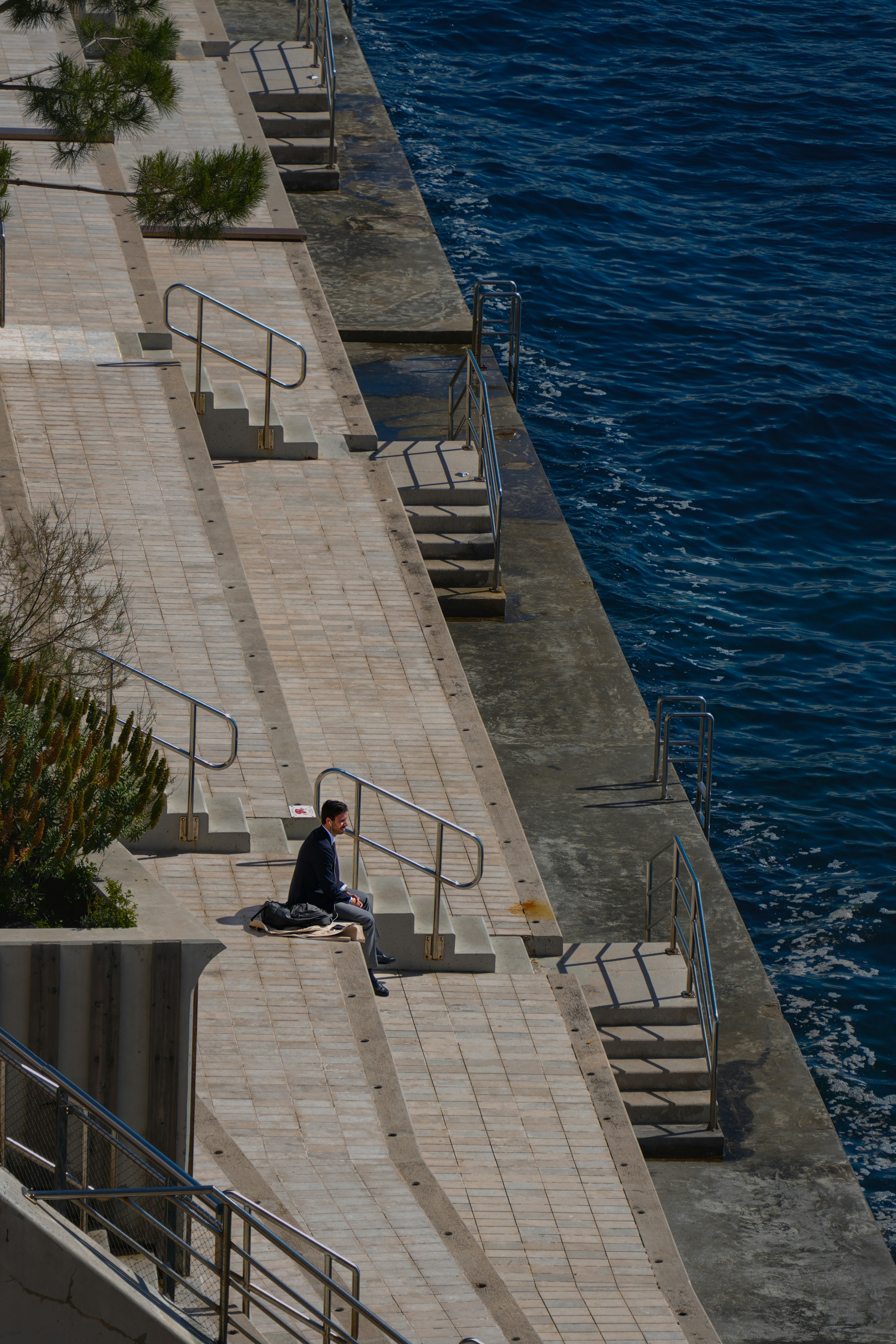 Lone Observer on the Serene Concrete Staircase by the Sea