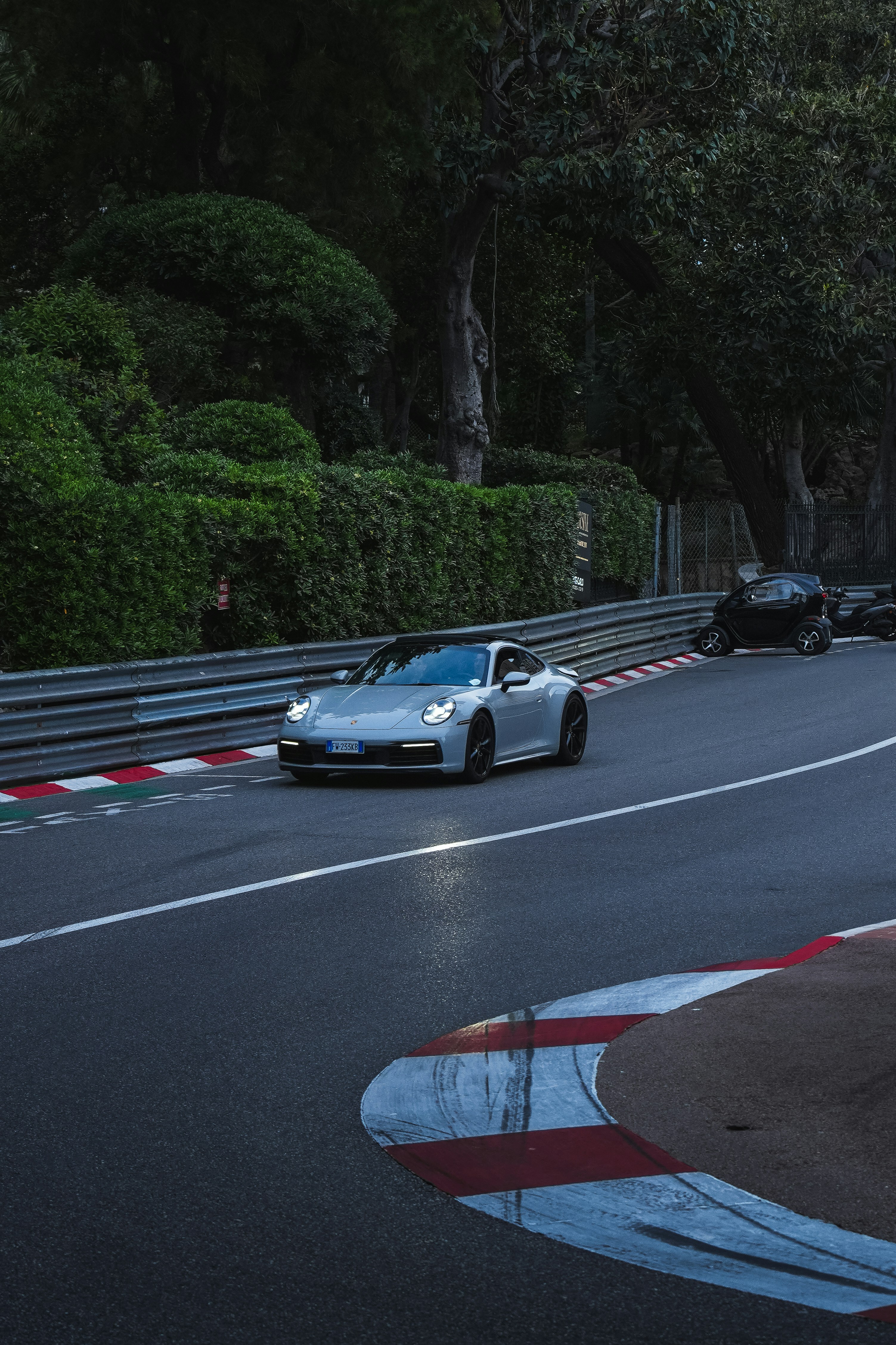 Blue Porsche Rounds the Curved Urban Road at Dusk