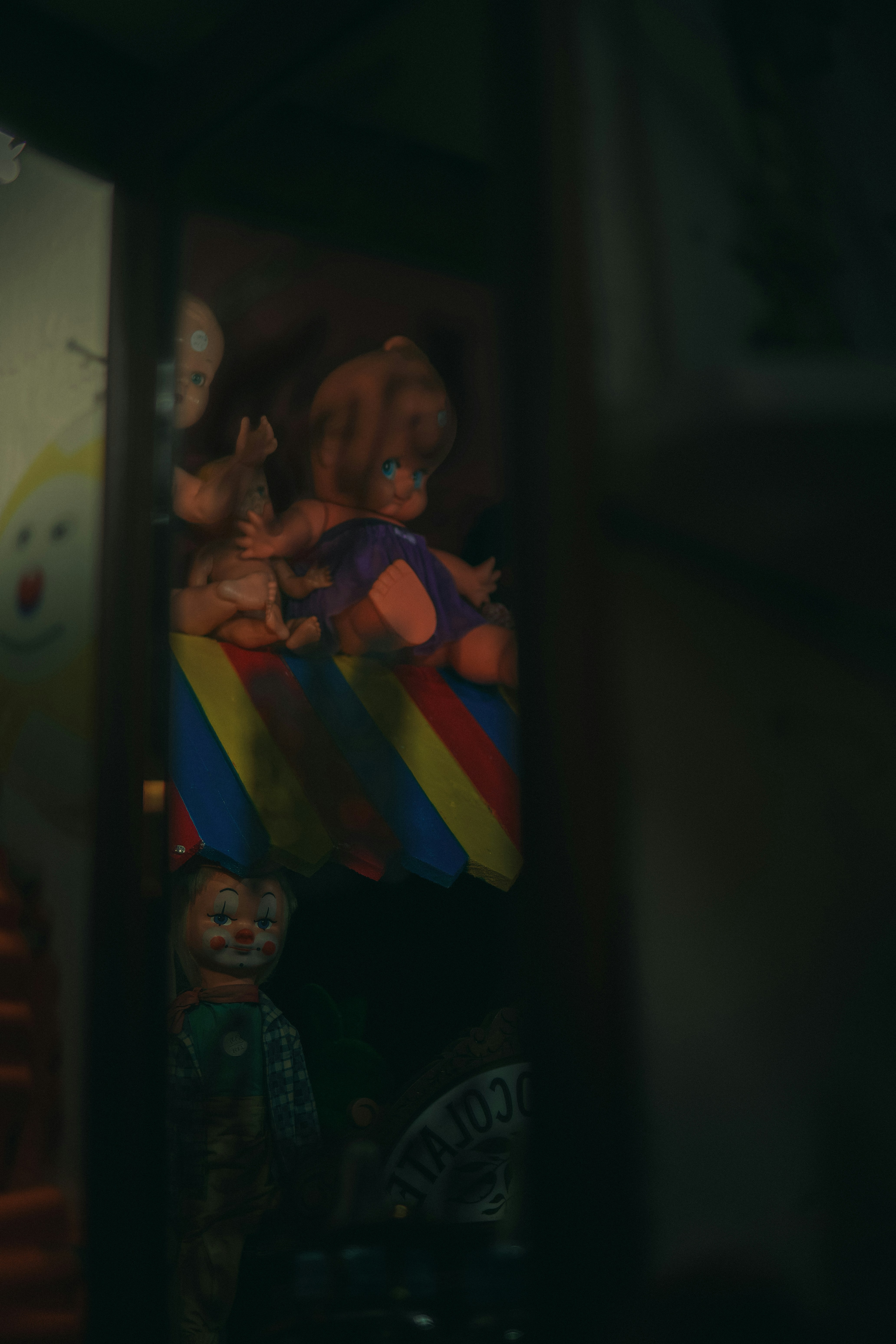 Sort of Toy Cabinet Mystery: Dim Shelf with Dolls in a Quiet Corner