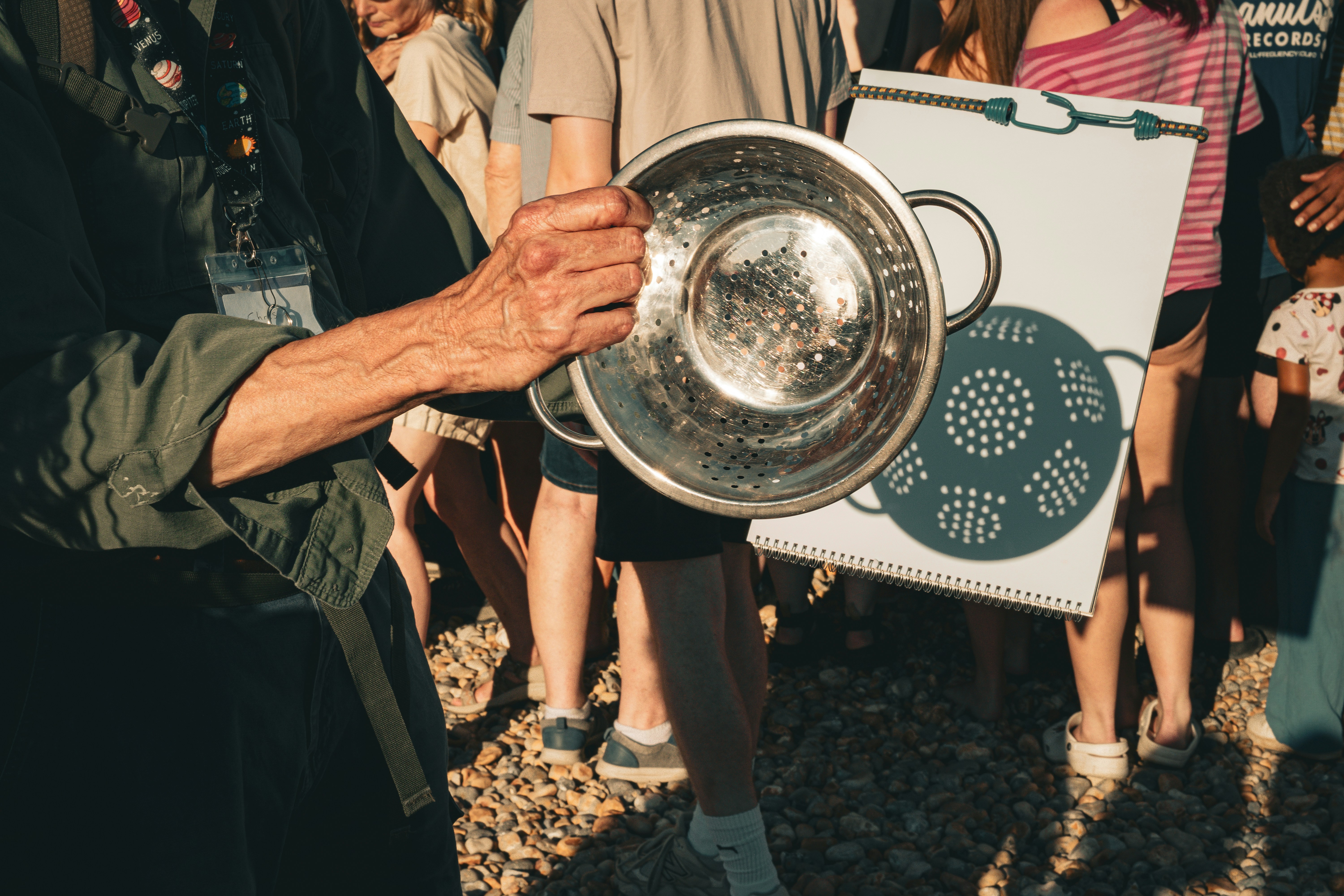 Polemic in the Spotlight: A Hand Grasping a Shiny Pan at a Crowd