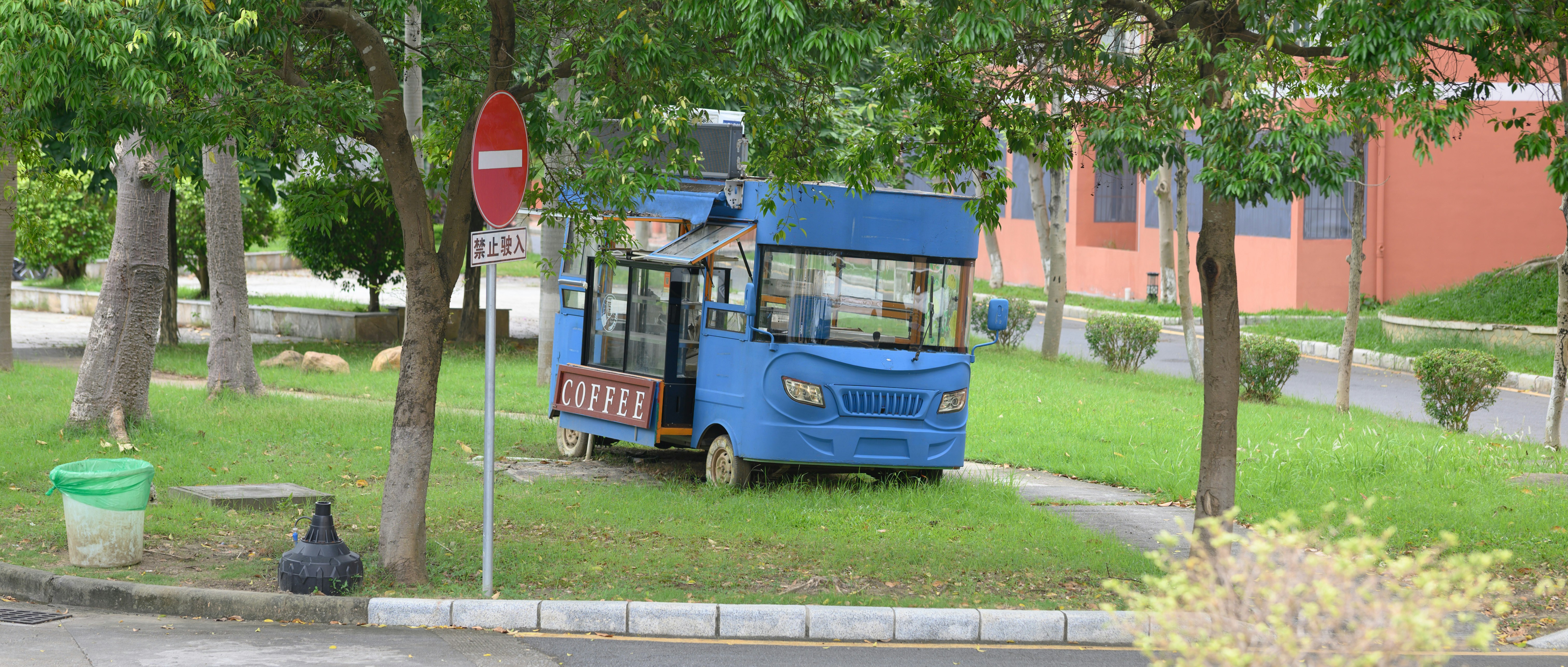 Blue Tourist Bus Turns Corner by the Park