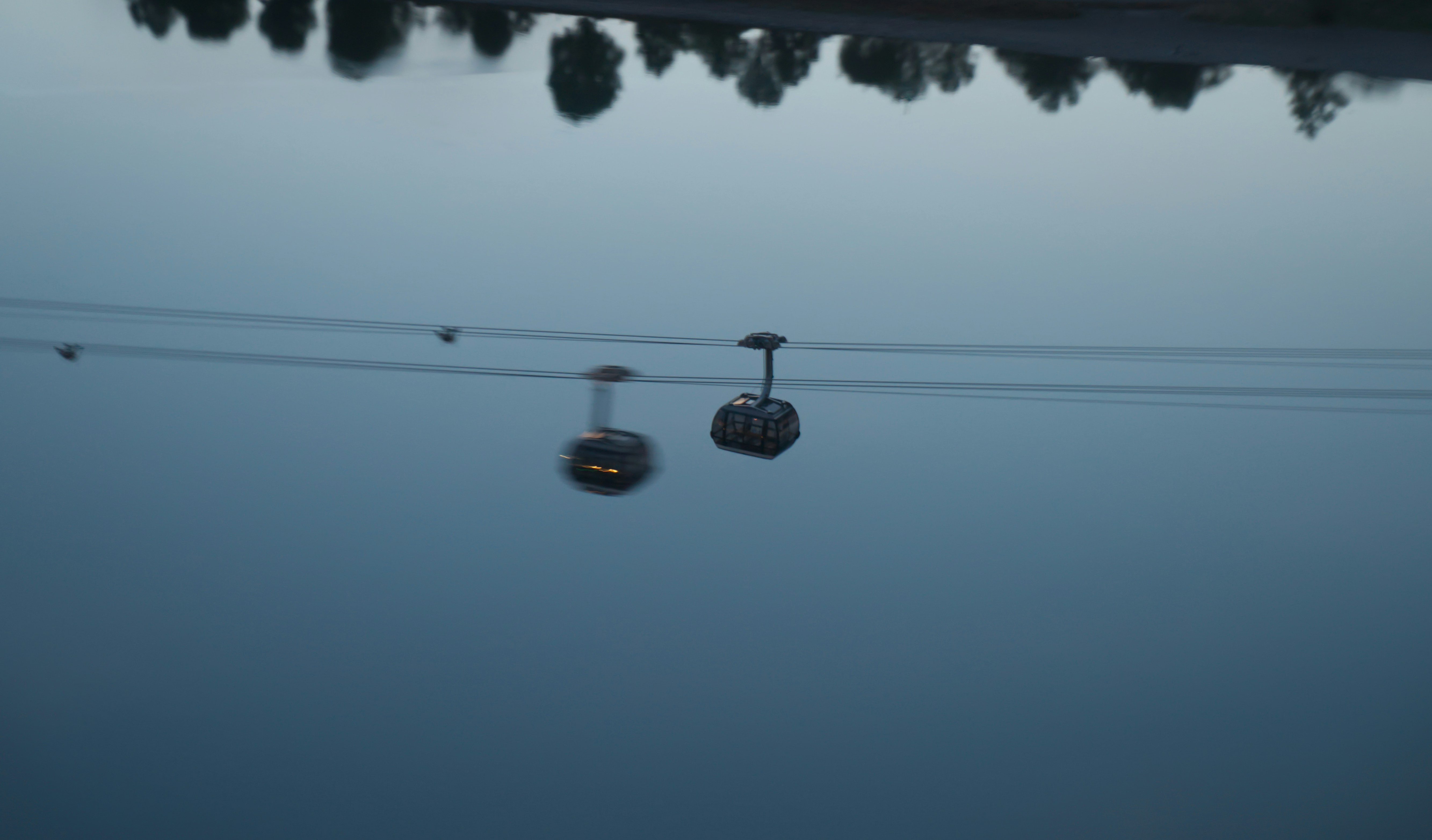 Upside-Down Lift: A Quiet Cable Car Moment Over Still Water
