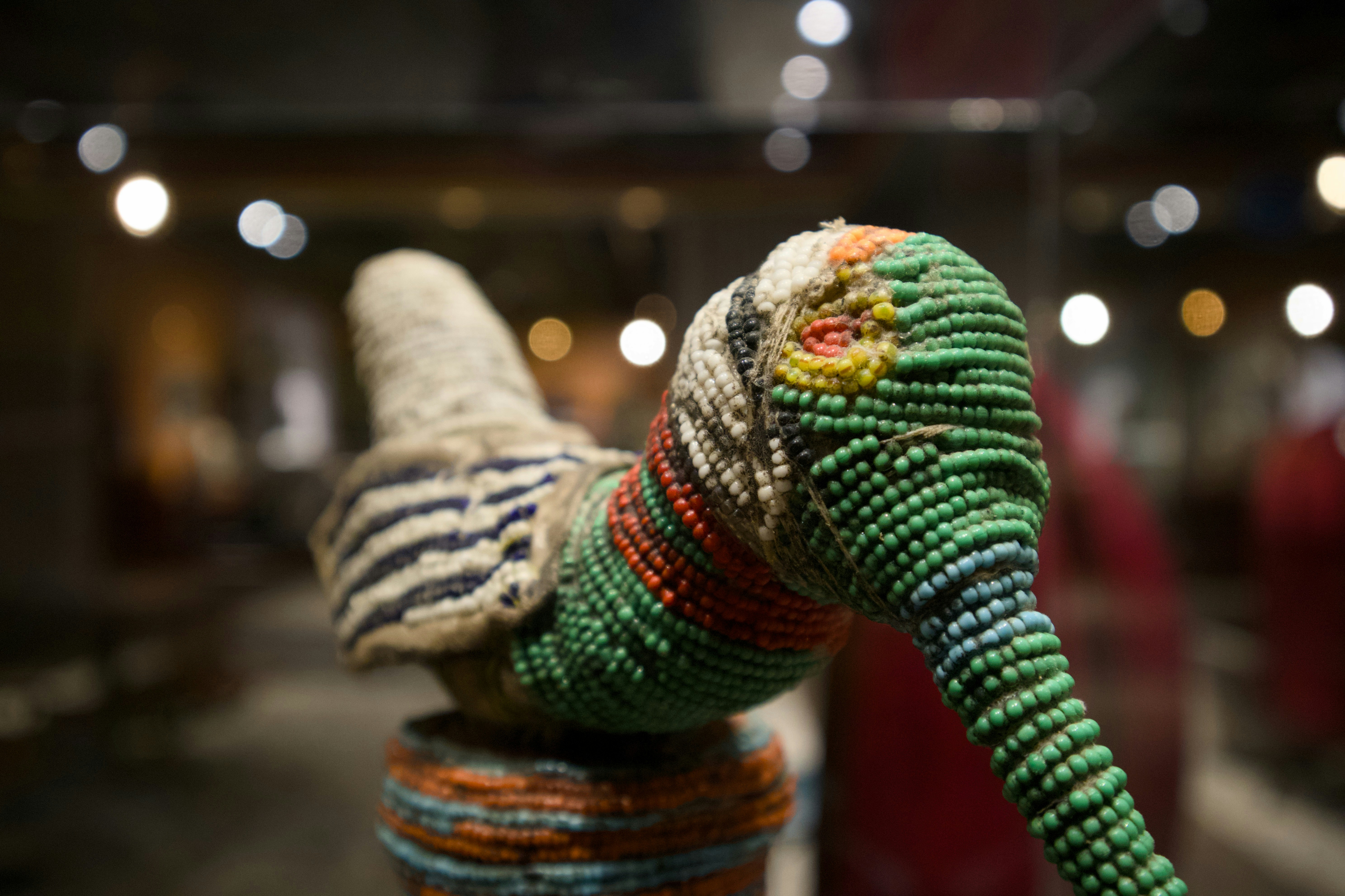 Beaded Serpent: A Colorful Glassy Gaze in a Museum Portrait