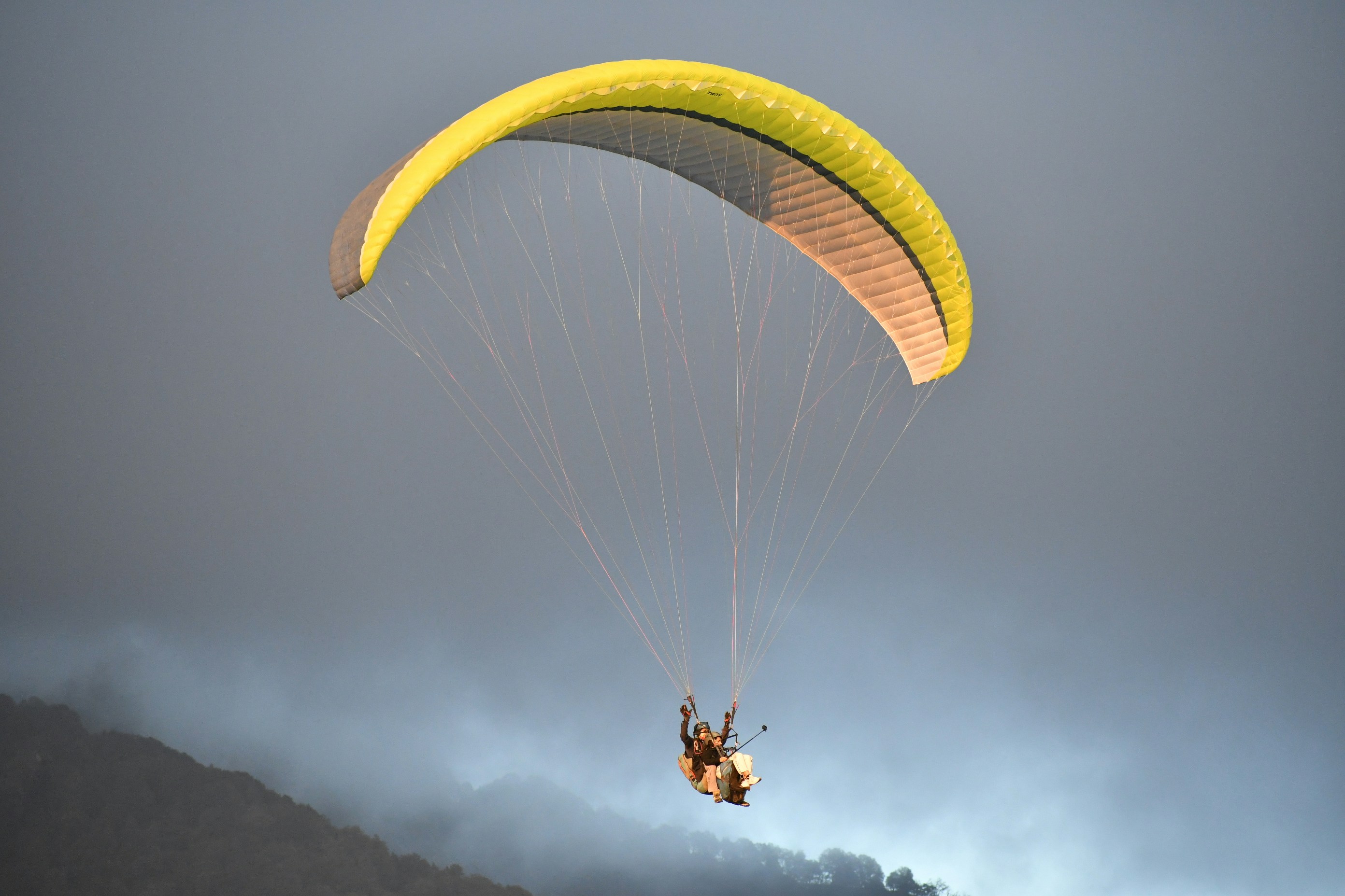 Soaring Above the Mist: A solitary paraglider against a moody horizon