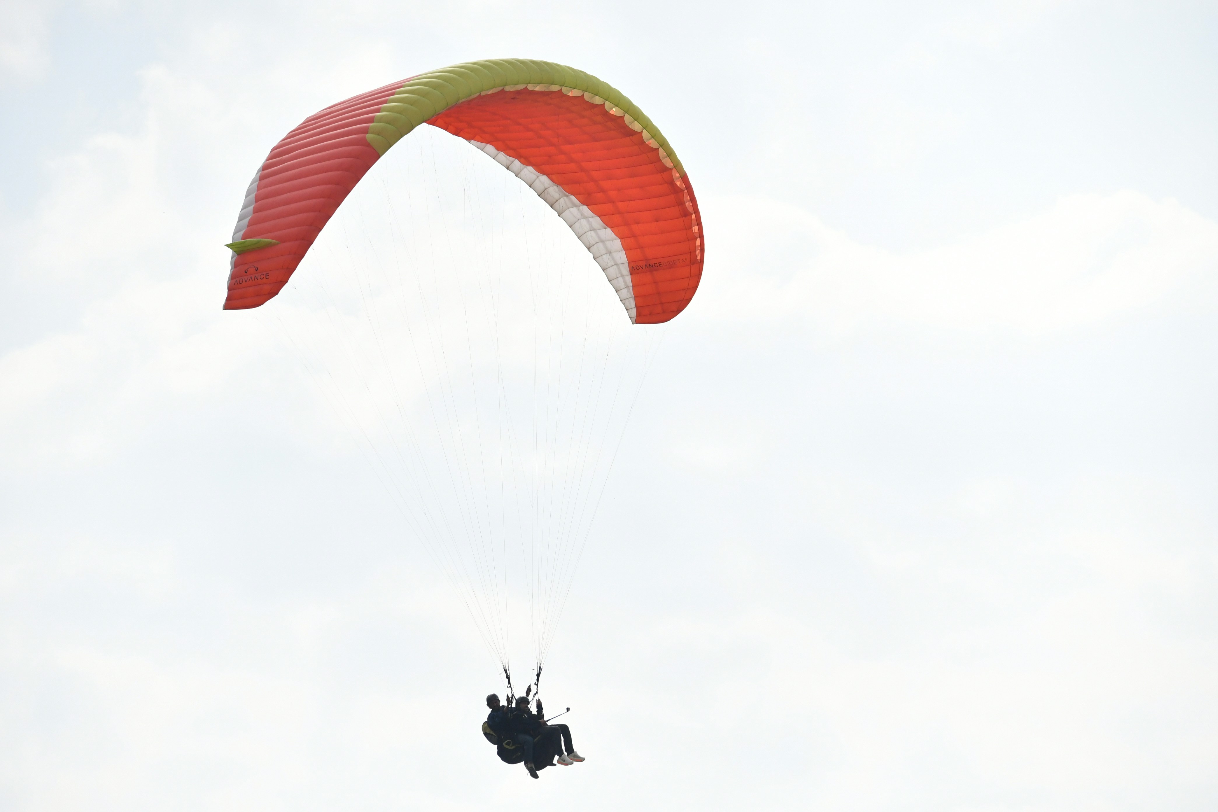 Suspended in the Sky: A Paraglider Quietly Glides Against a Bright Cloudscape