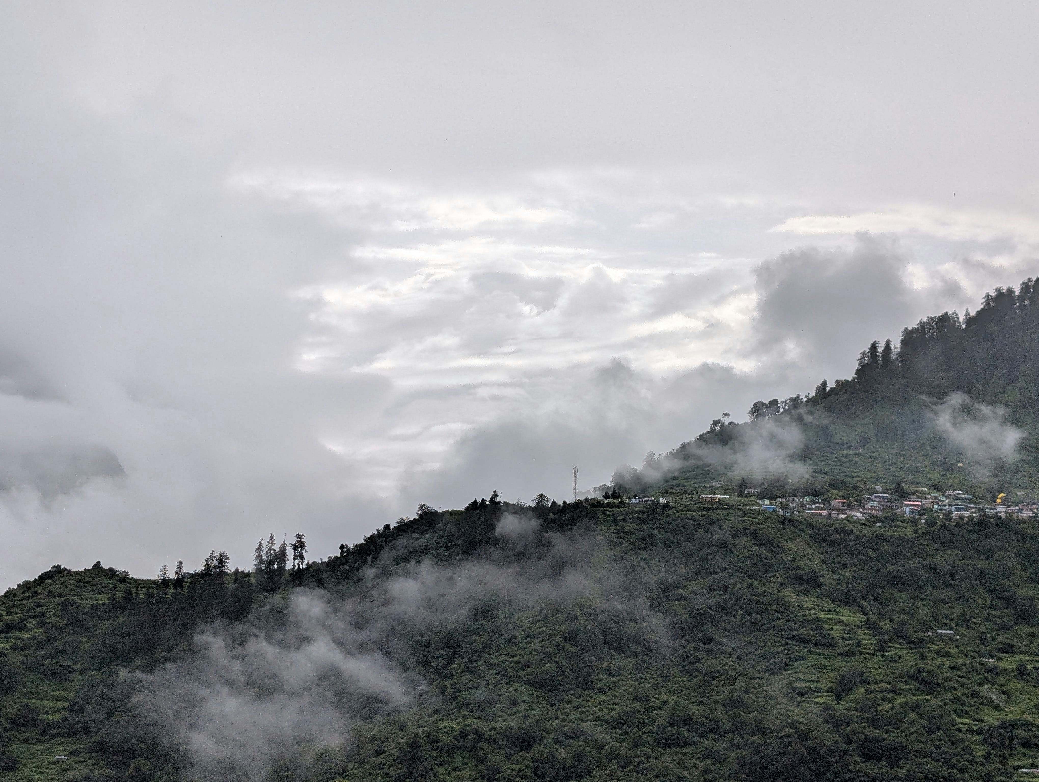 Mist over the ridge: a quiet hillside village tucked into green slopes