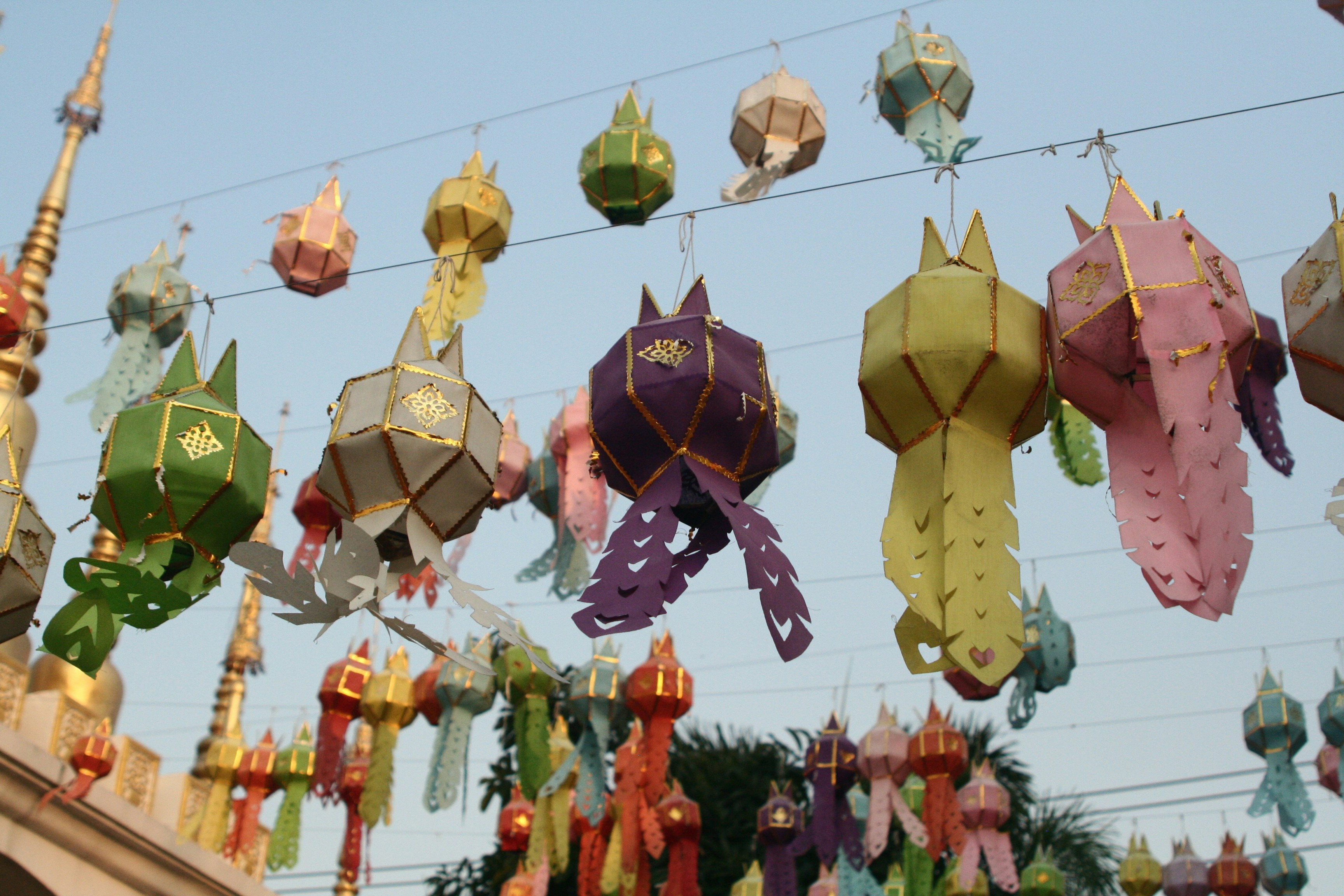 Colorful Lanterns Swinging Against a Clear Sky