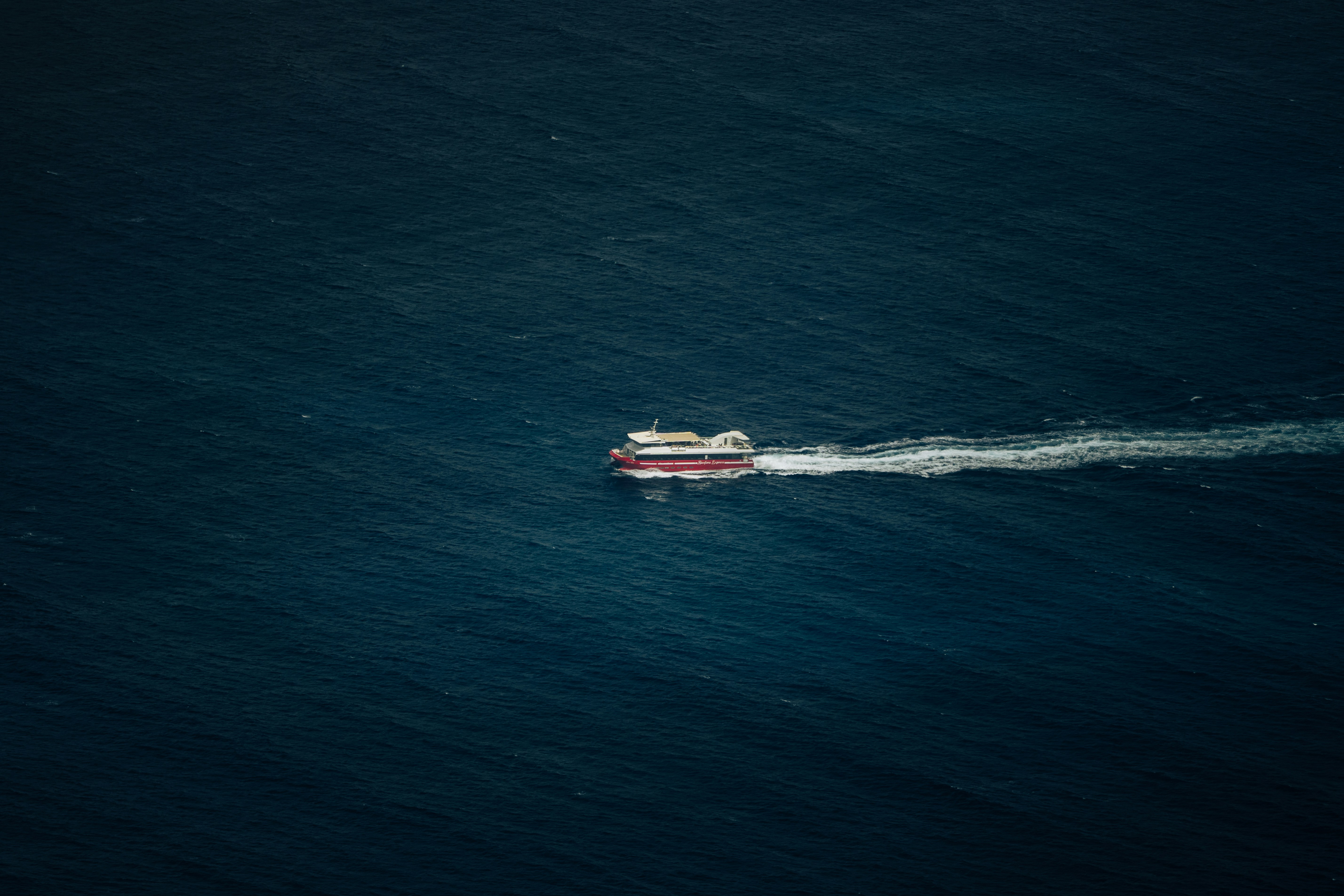 Mid-Ocean Escape: A lone speedboat carving a white wake through deep blue