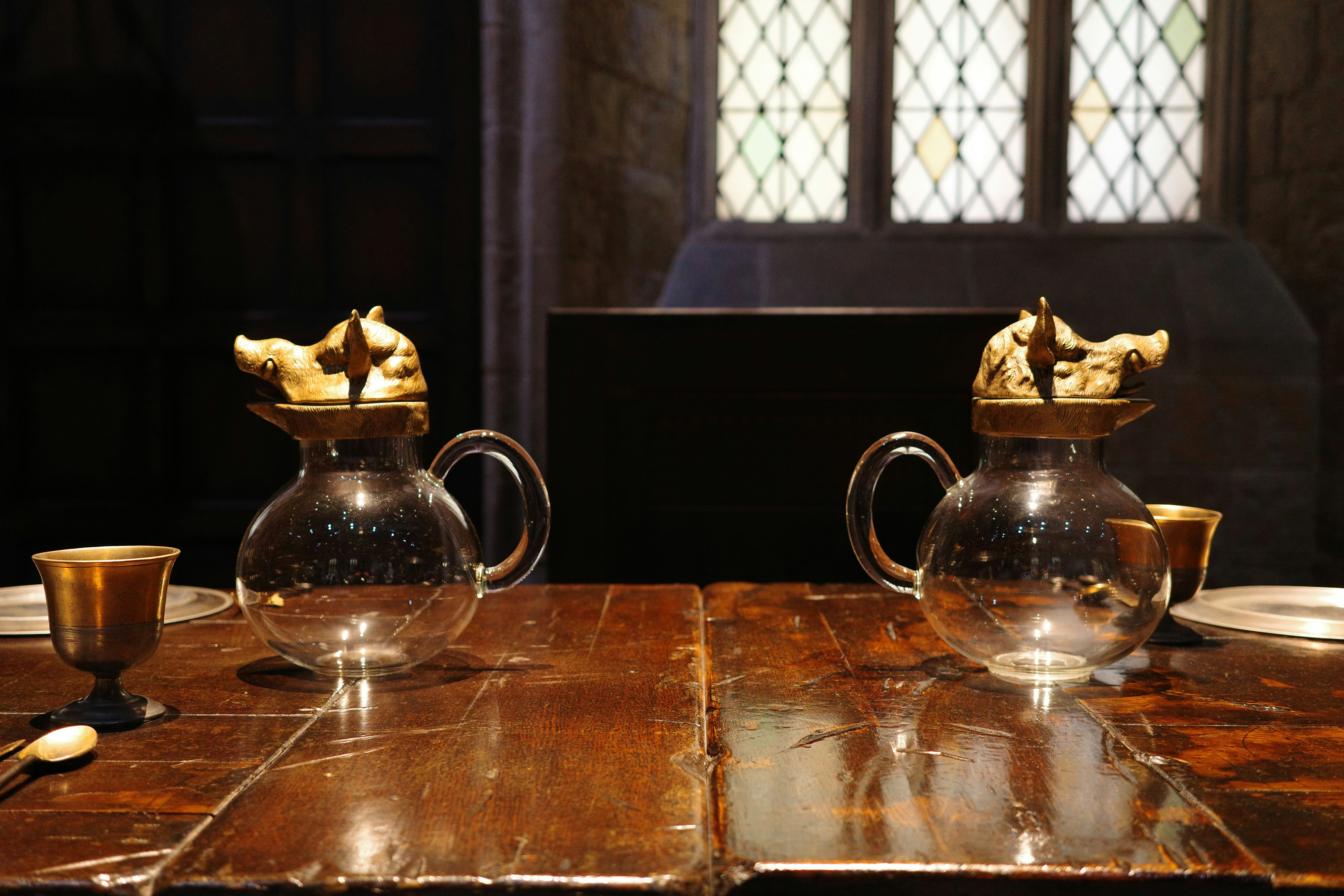 Twin Brass-Crowned Urn Grasped by Amber Light