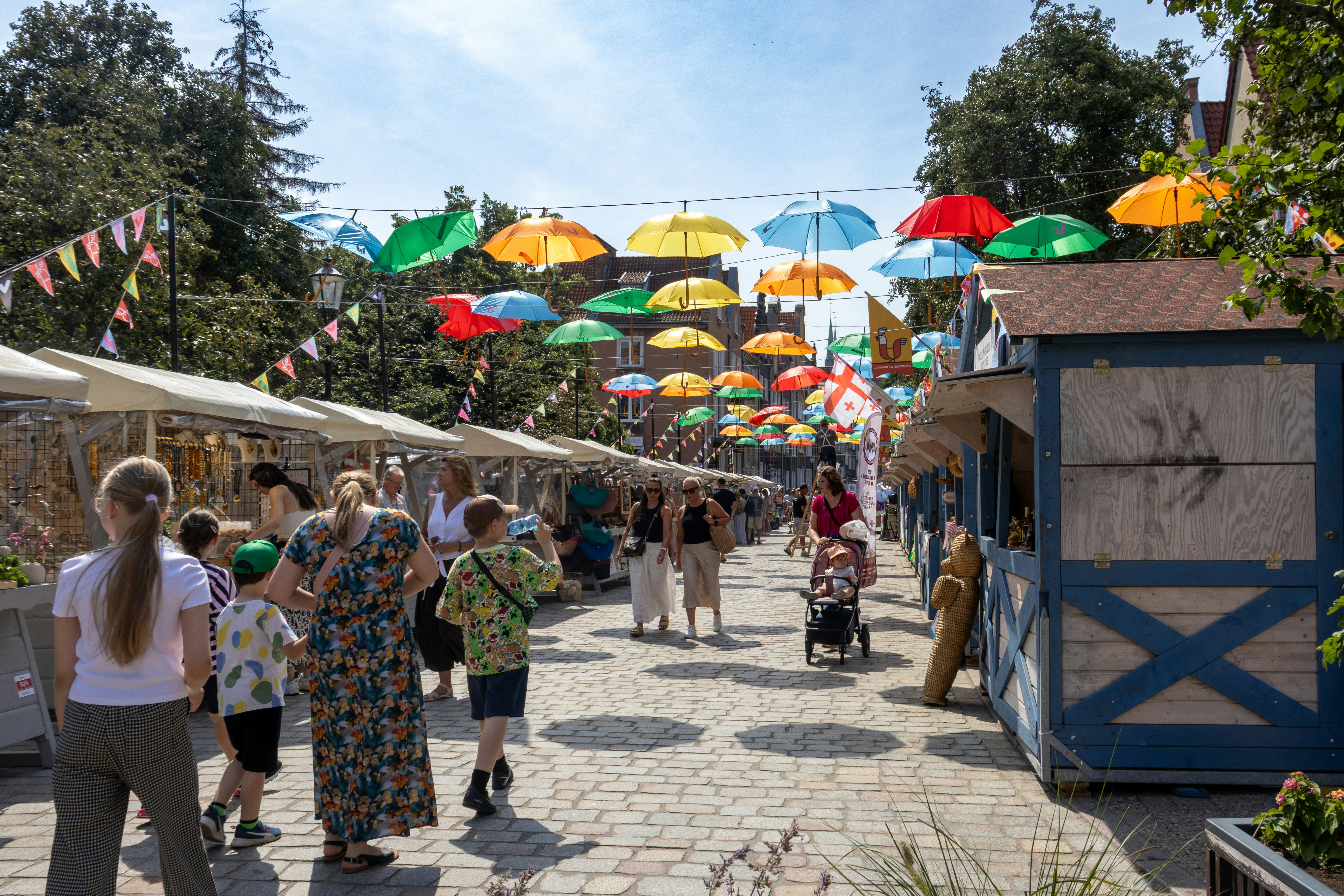 Sunlit Street Festival Under a Rainbow of Parasol Canopies
