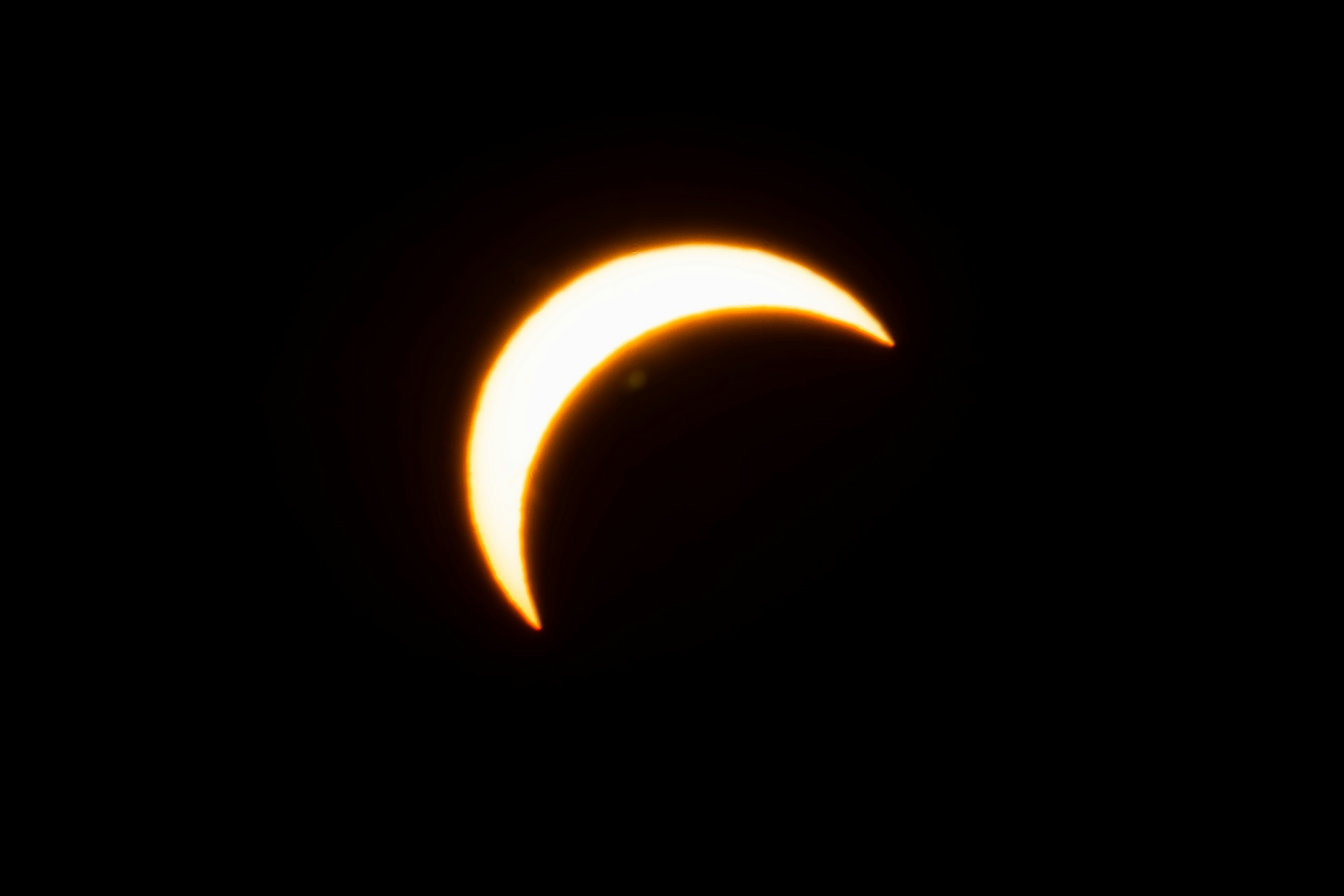 Crescent Sun: A Quiet Solar Eclipse Casting a Small Crescent Against Darkness
