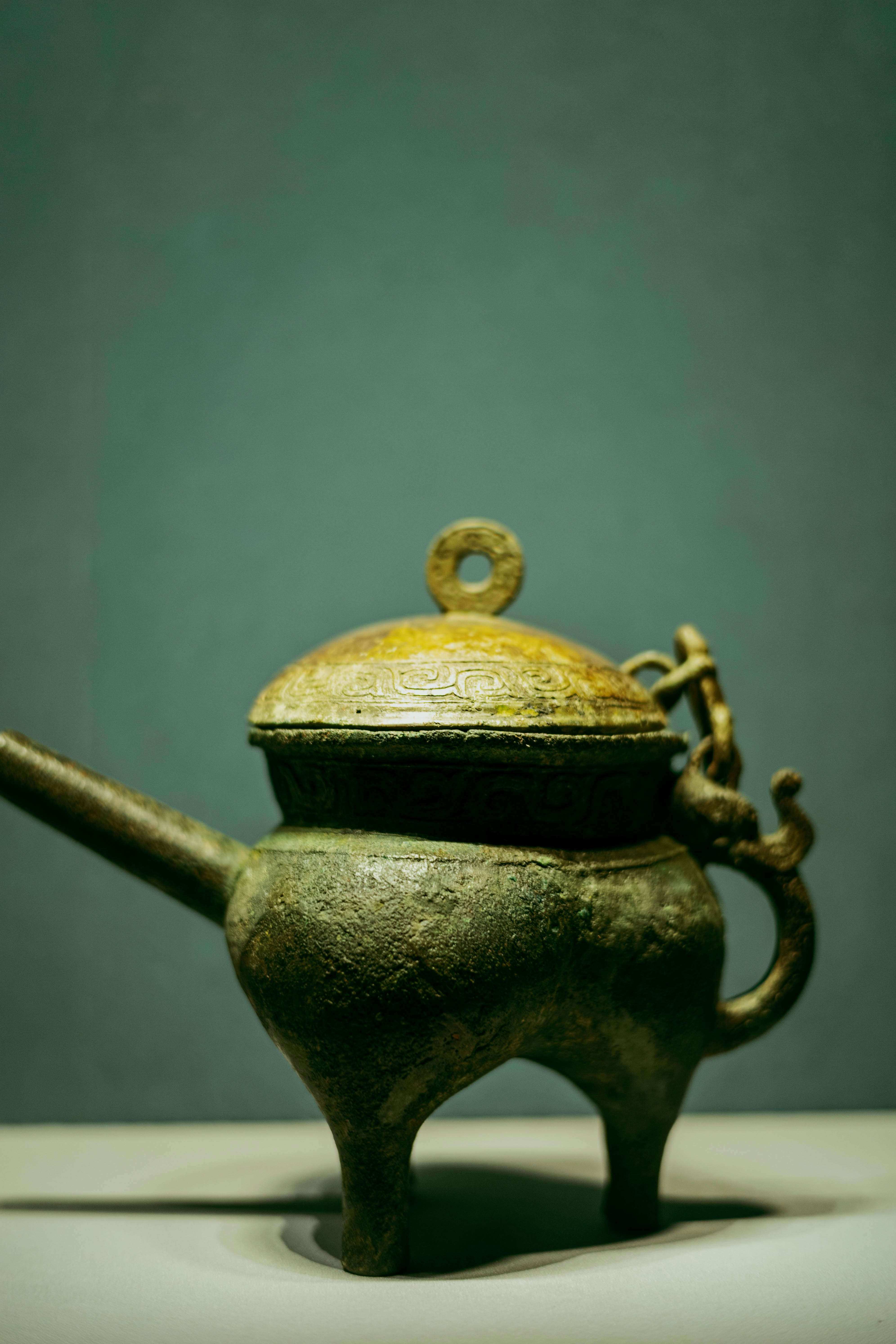 Ancient Teapot of Green Patina on a Quiet Table