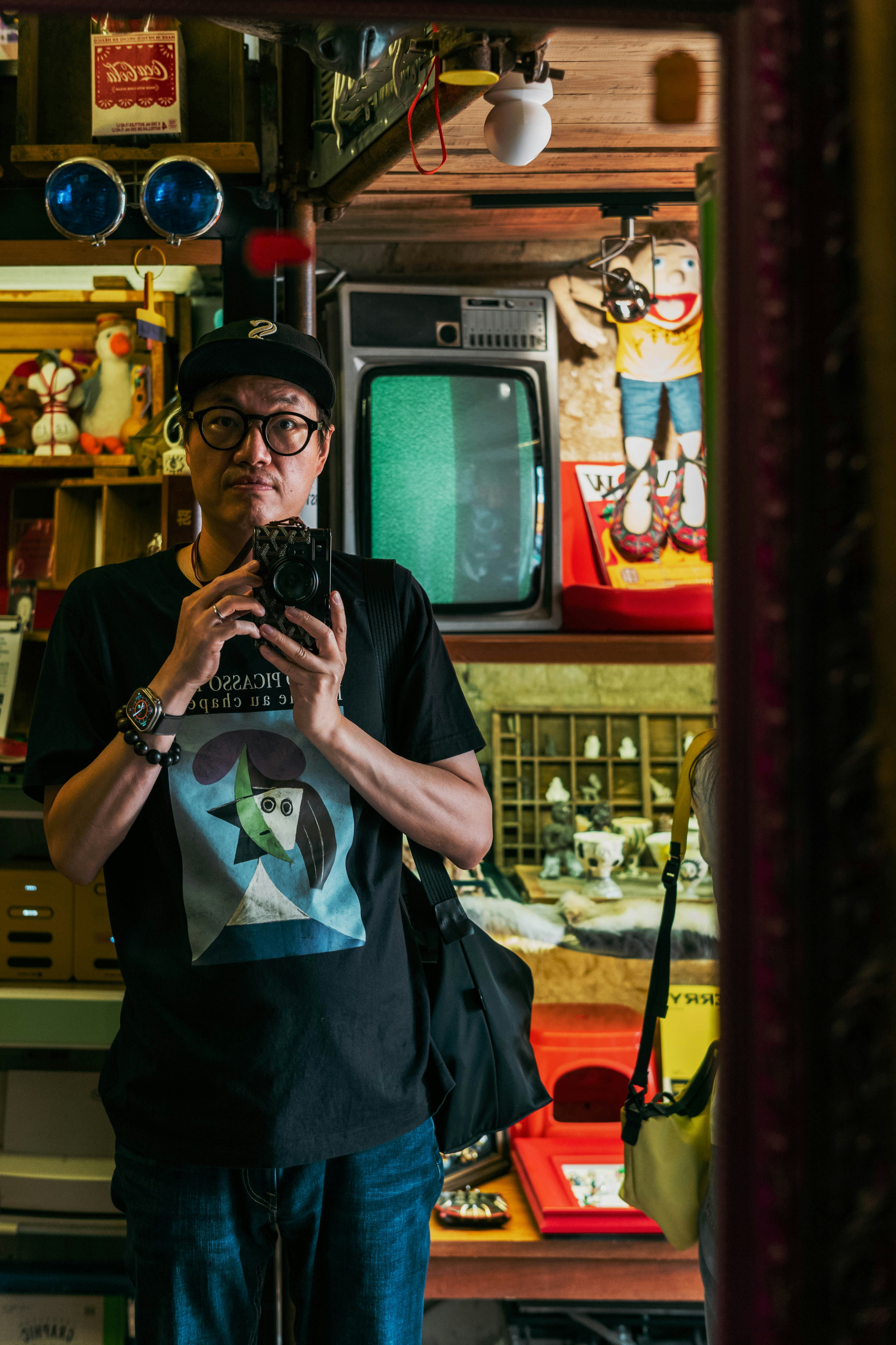 Self-portrait in a vintage cluttered shop: the camera and the collector