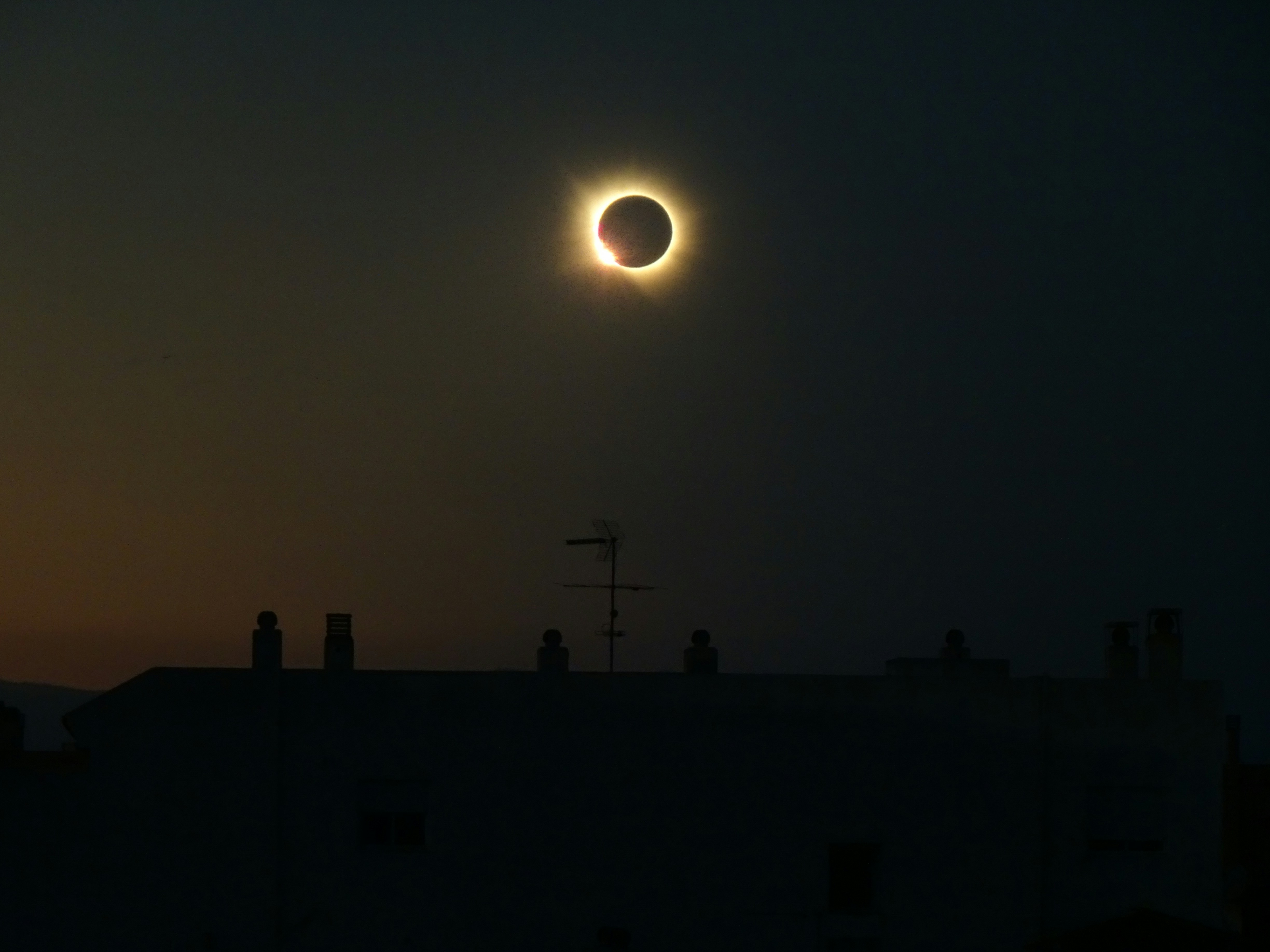 Partial Eclipse Over Rooftops: A Quiet Night Sky