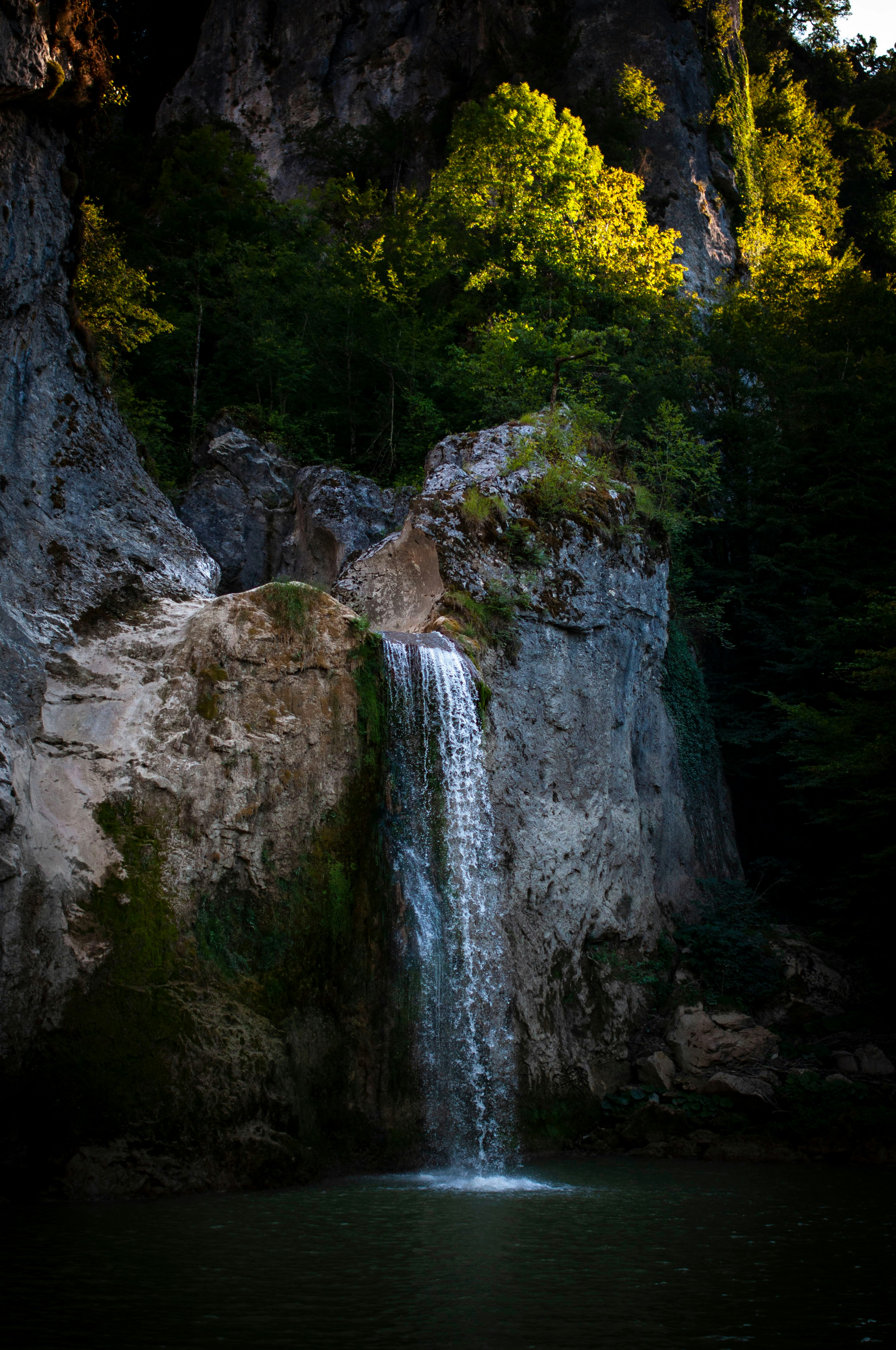 Sunlit Crest: A Narrow Cascade Between Mossy Cliffs