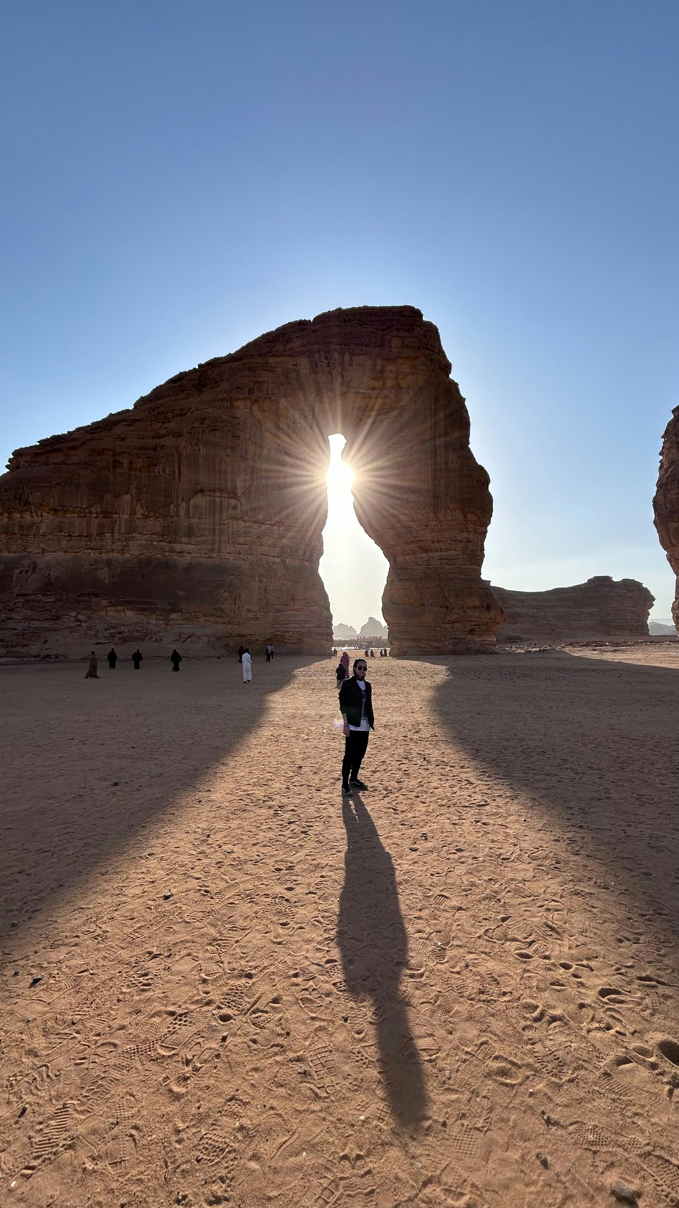 Sunlit Arch Corridor: A Lone Wanderer Beneath a Natural Gateway