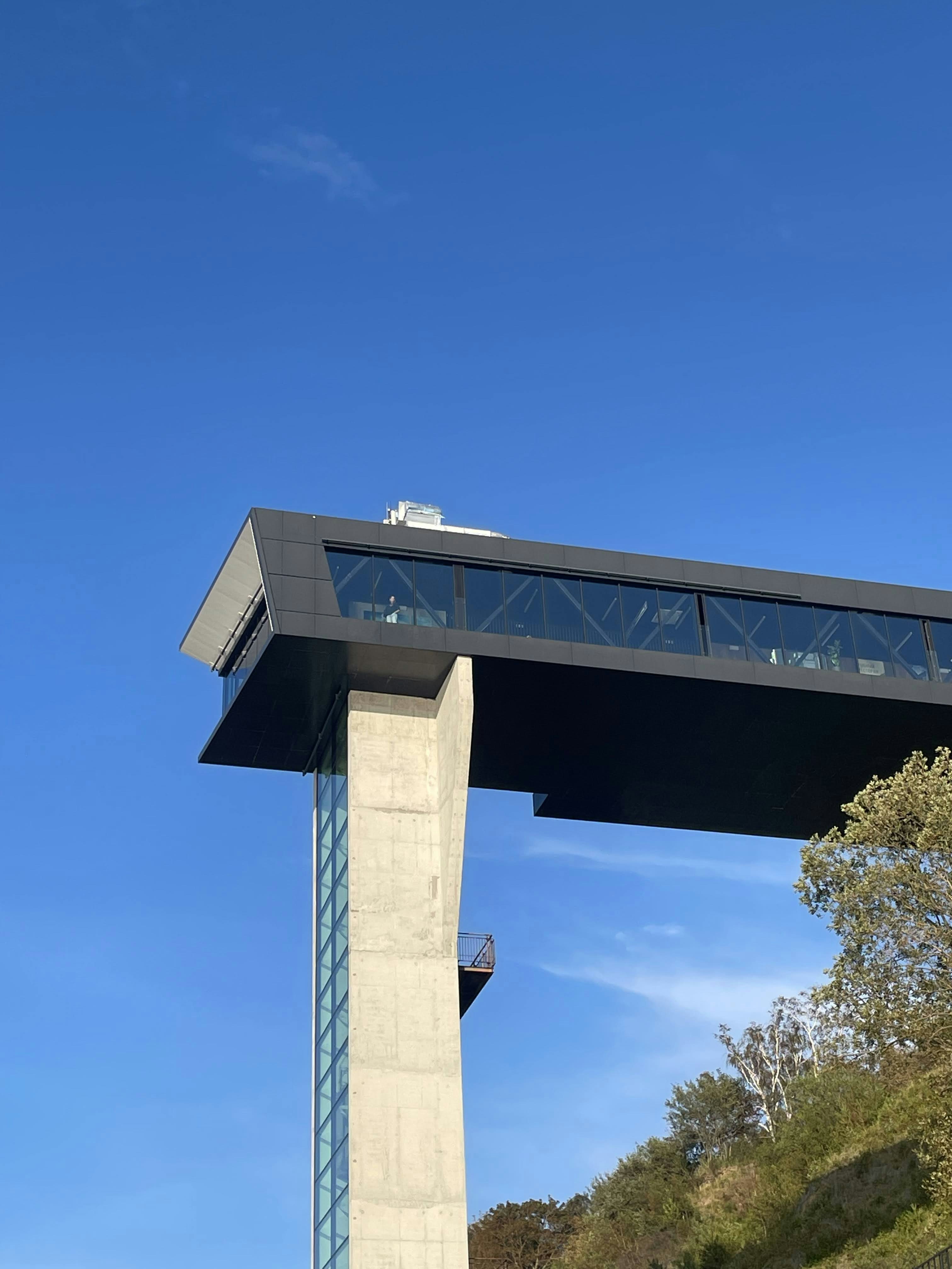 Bridge Wing Io: A Sky-High Corridor Over a Blue Plane