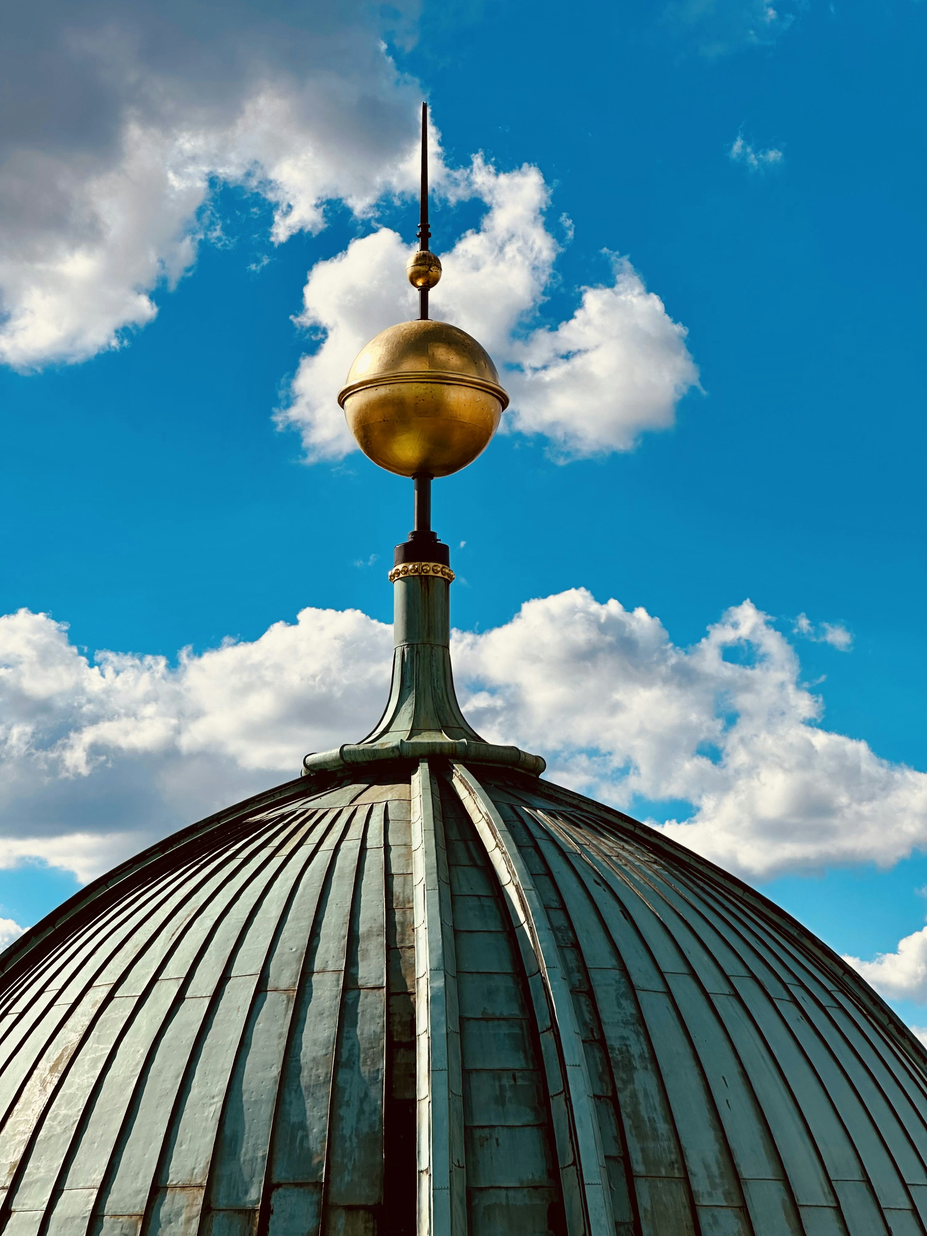 Golden Sphere Crowned Above a Copper Dome Under a Cerulean Sky
