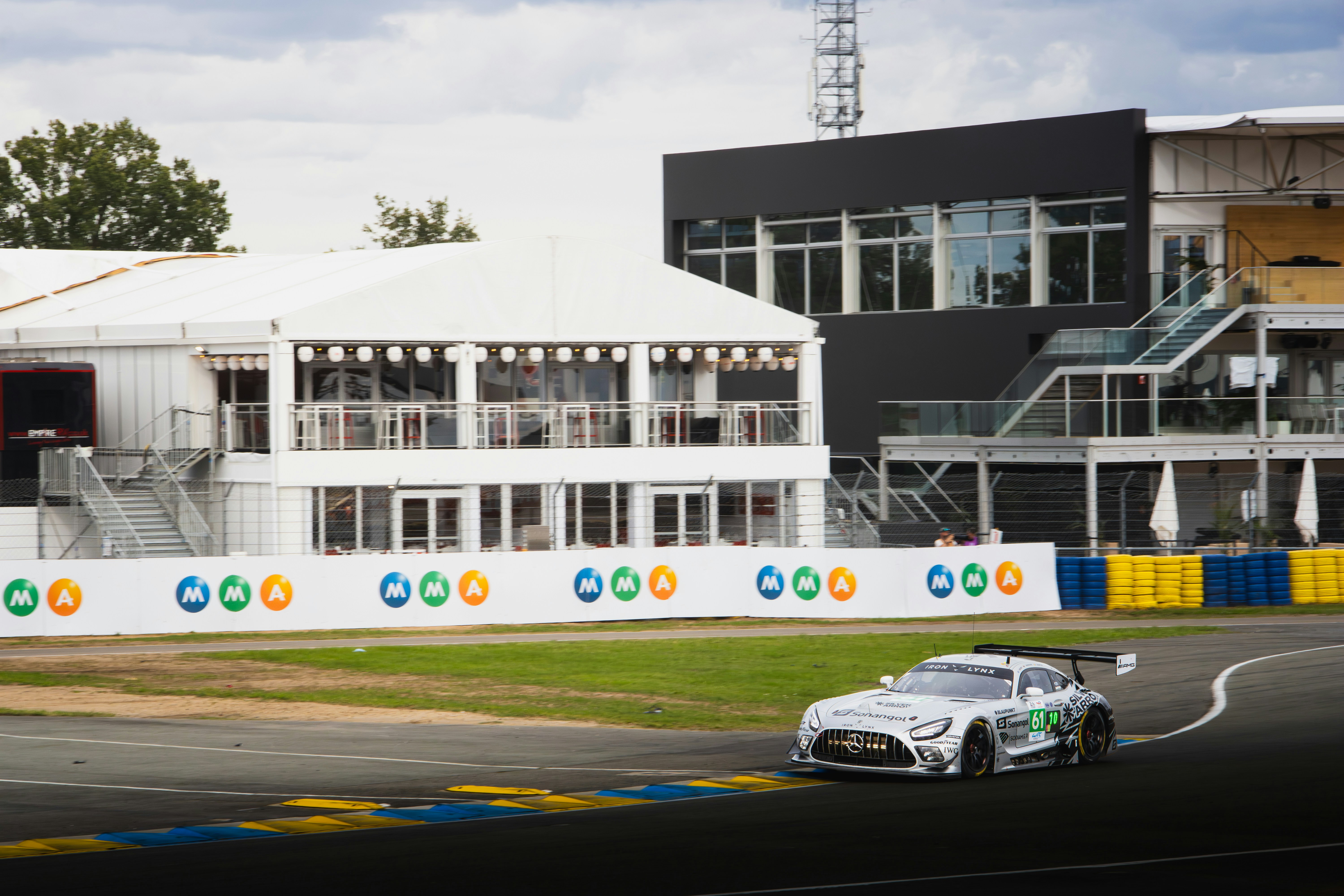 Racecar Slices the Track Past the Paddock Glass