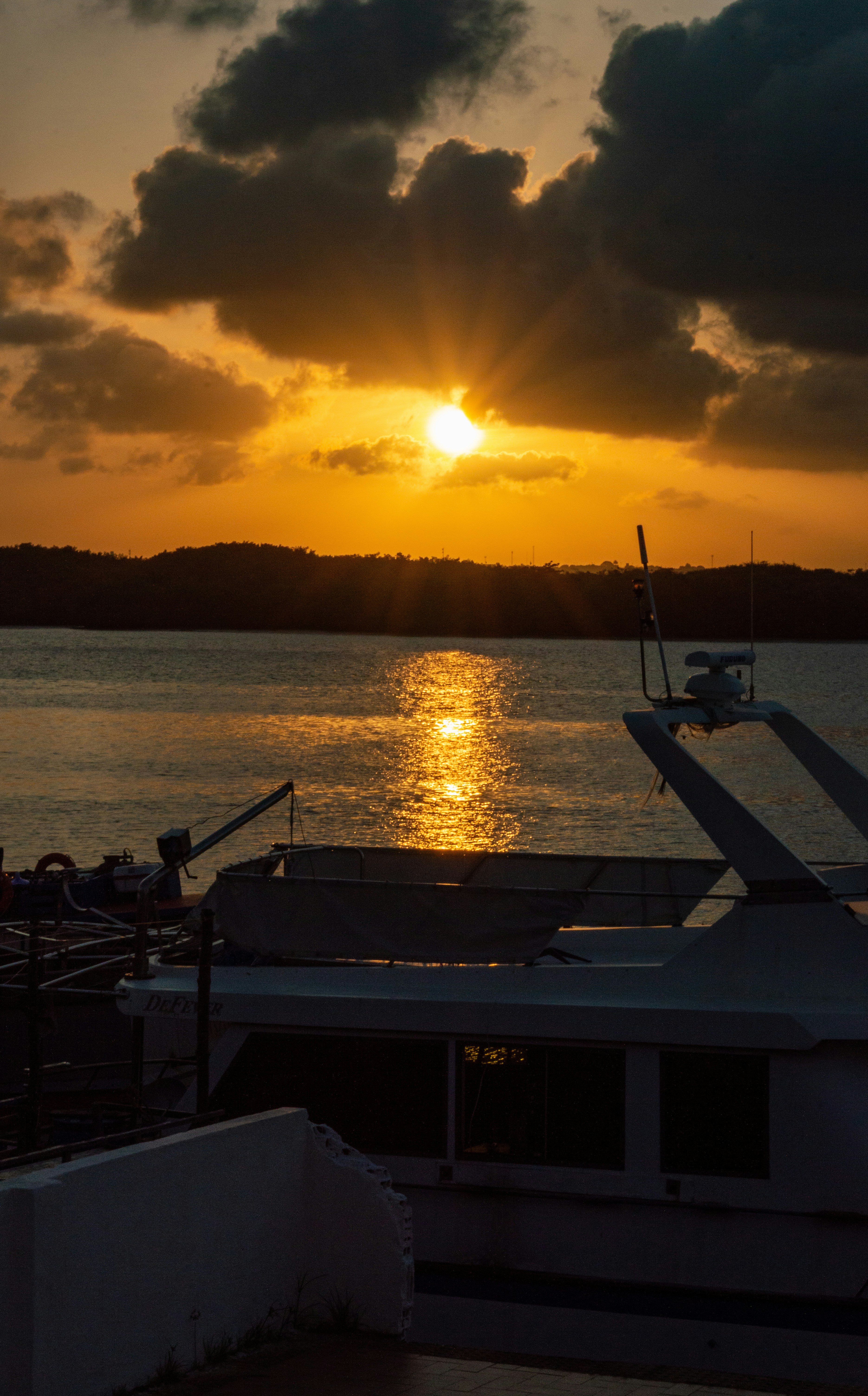 Sunset Over Quiet Harbor: Boats Silhouetted Against a Glowing Horizon