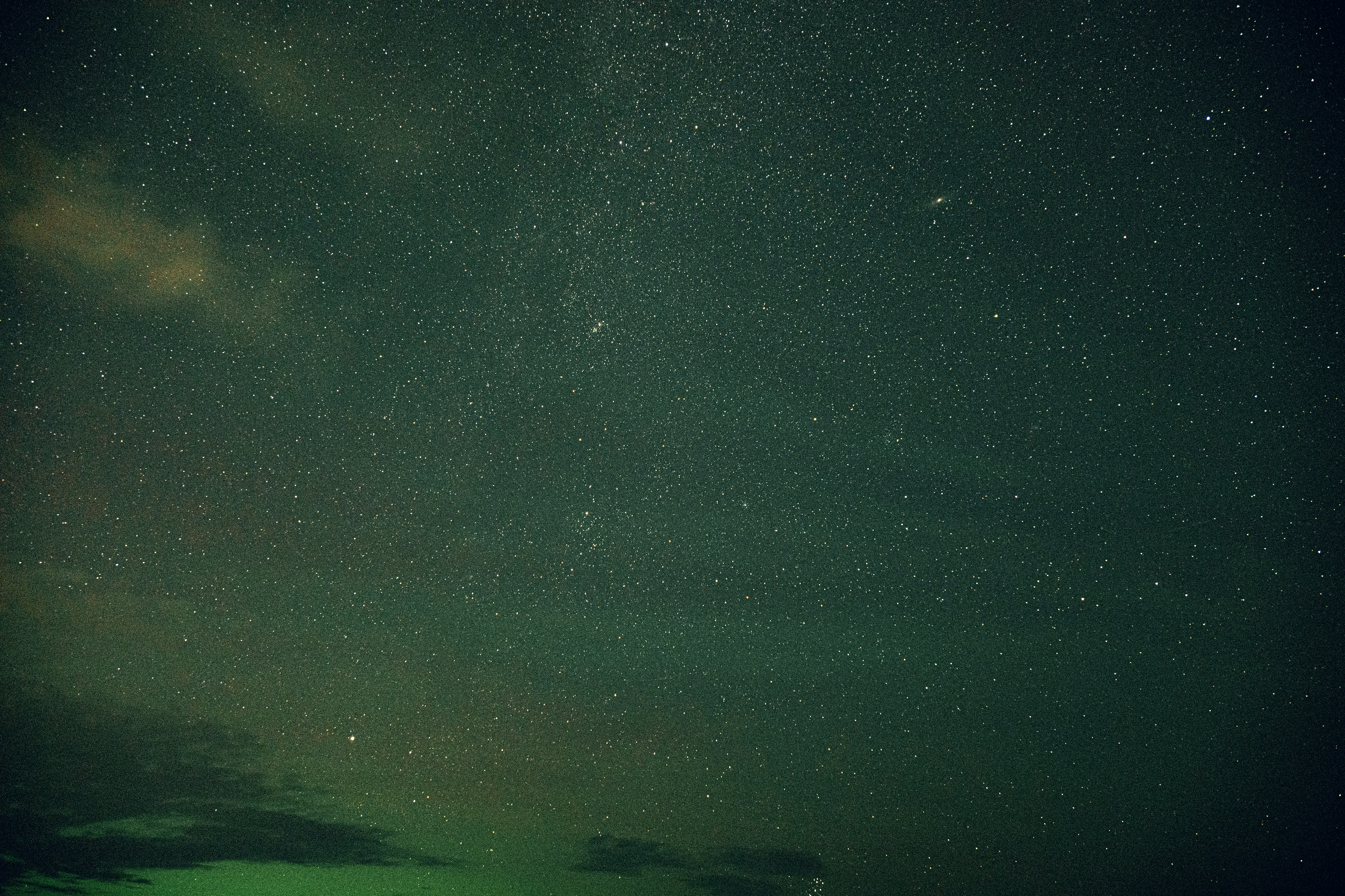 Stellar Veil: A Quiet Night Sky Over Green Horizon