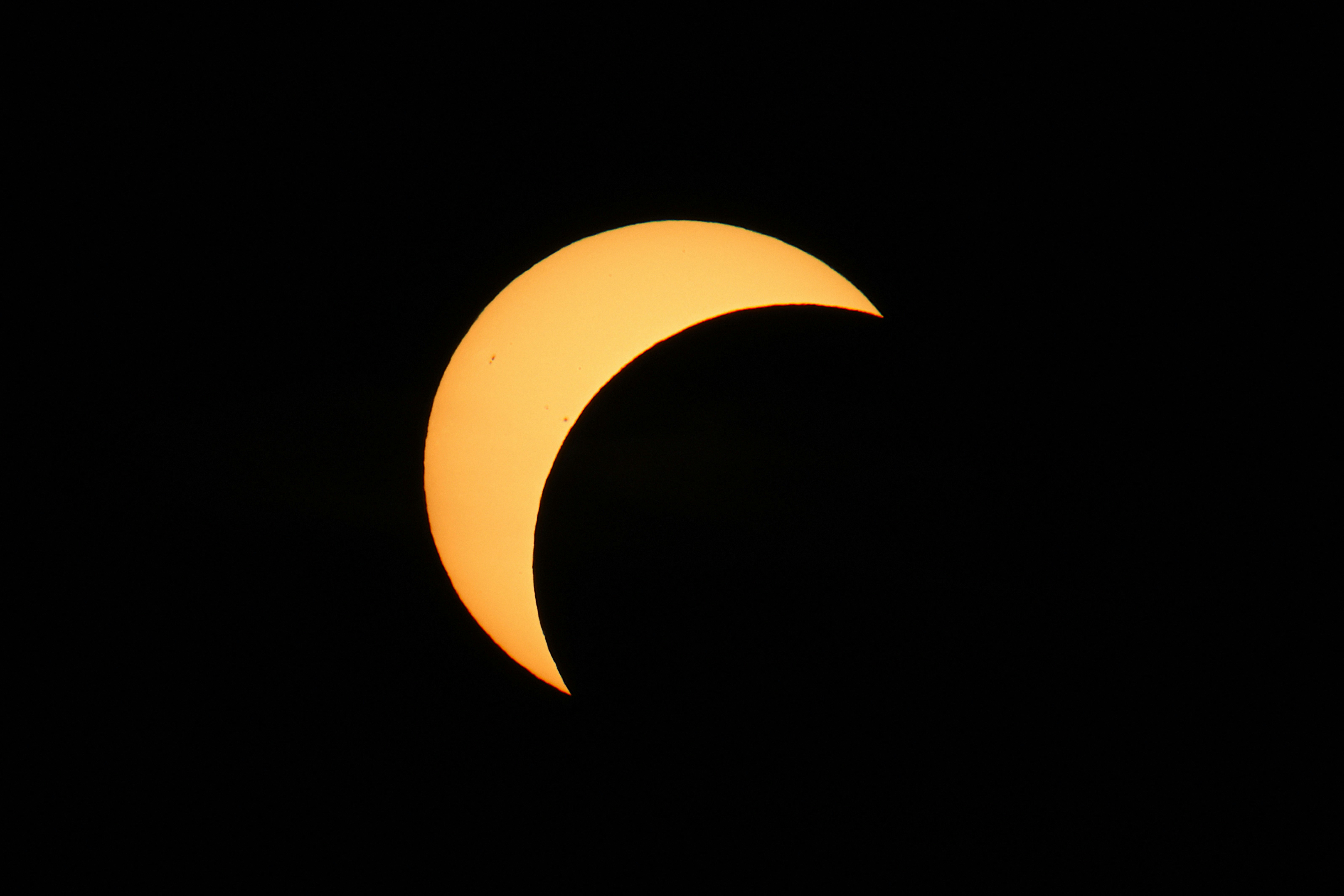 Partial Solar Eclipse: a glowing crescent against darkness