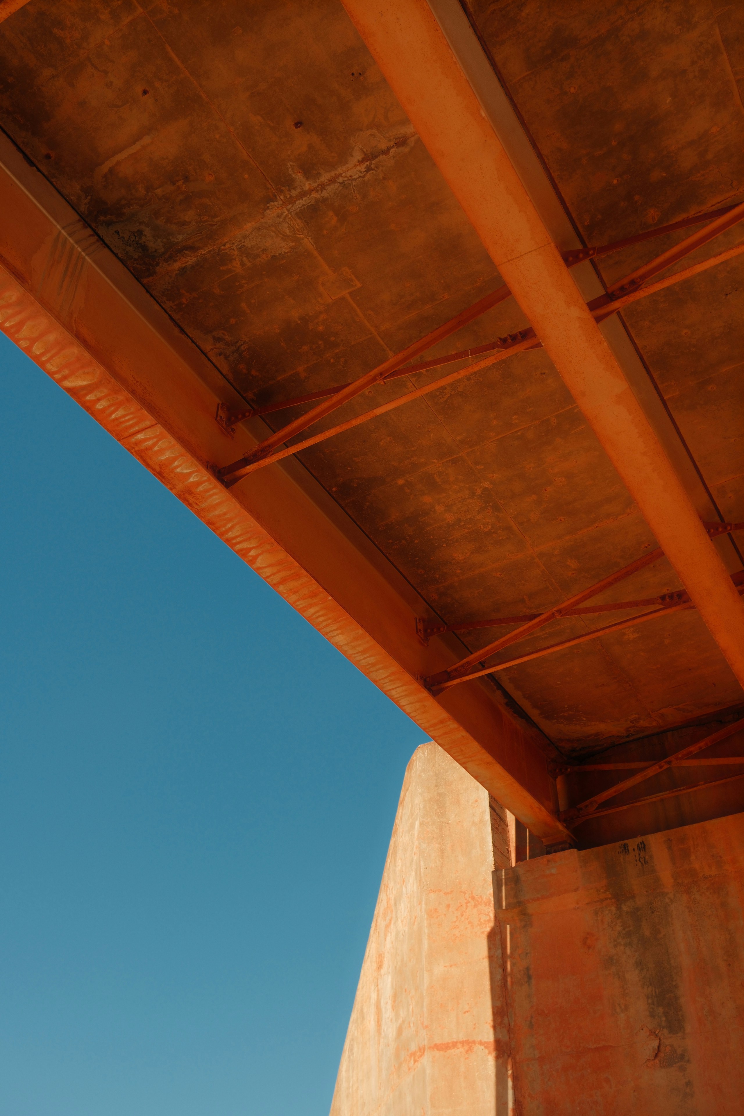 Orange Capillaries: A Concrete Steel Prelude Beneath Blue Skies
