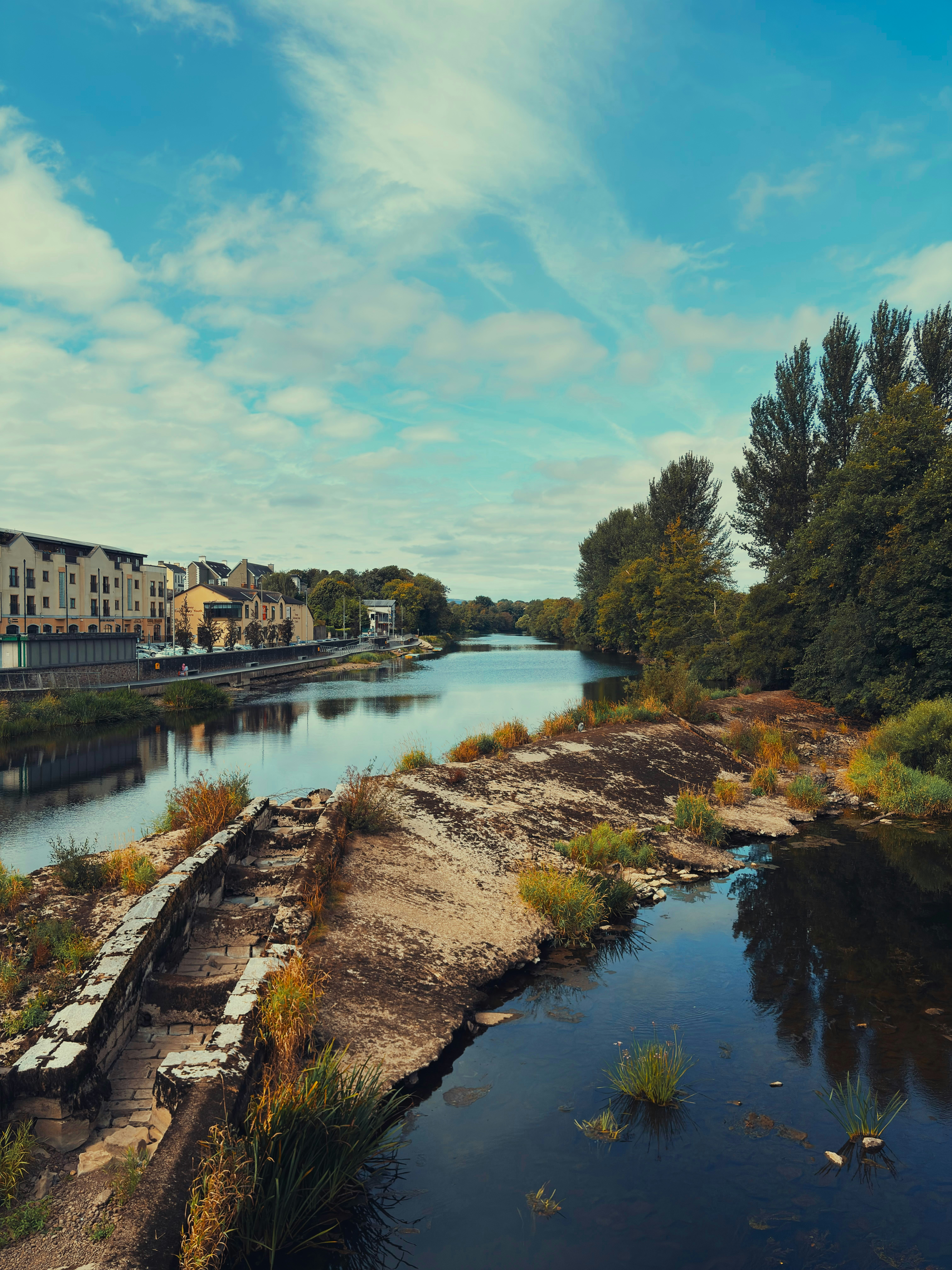 Riverside Quarry Meets Townscape Under a Sky of Soft Clouds