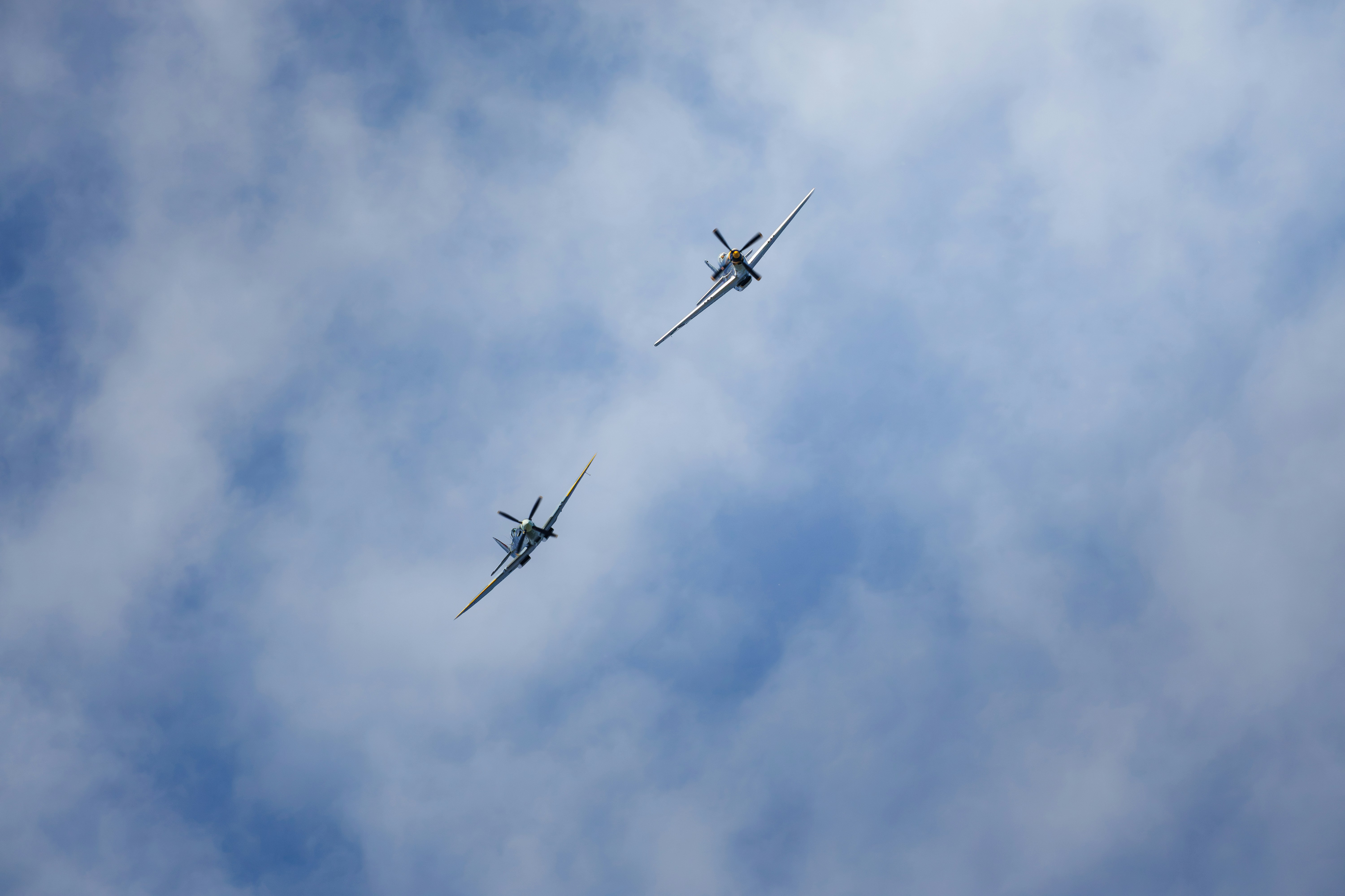 Mid-air Duo: A pair of vintage fighters slicing through a blue sky