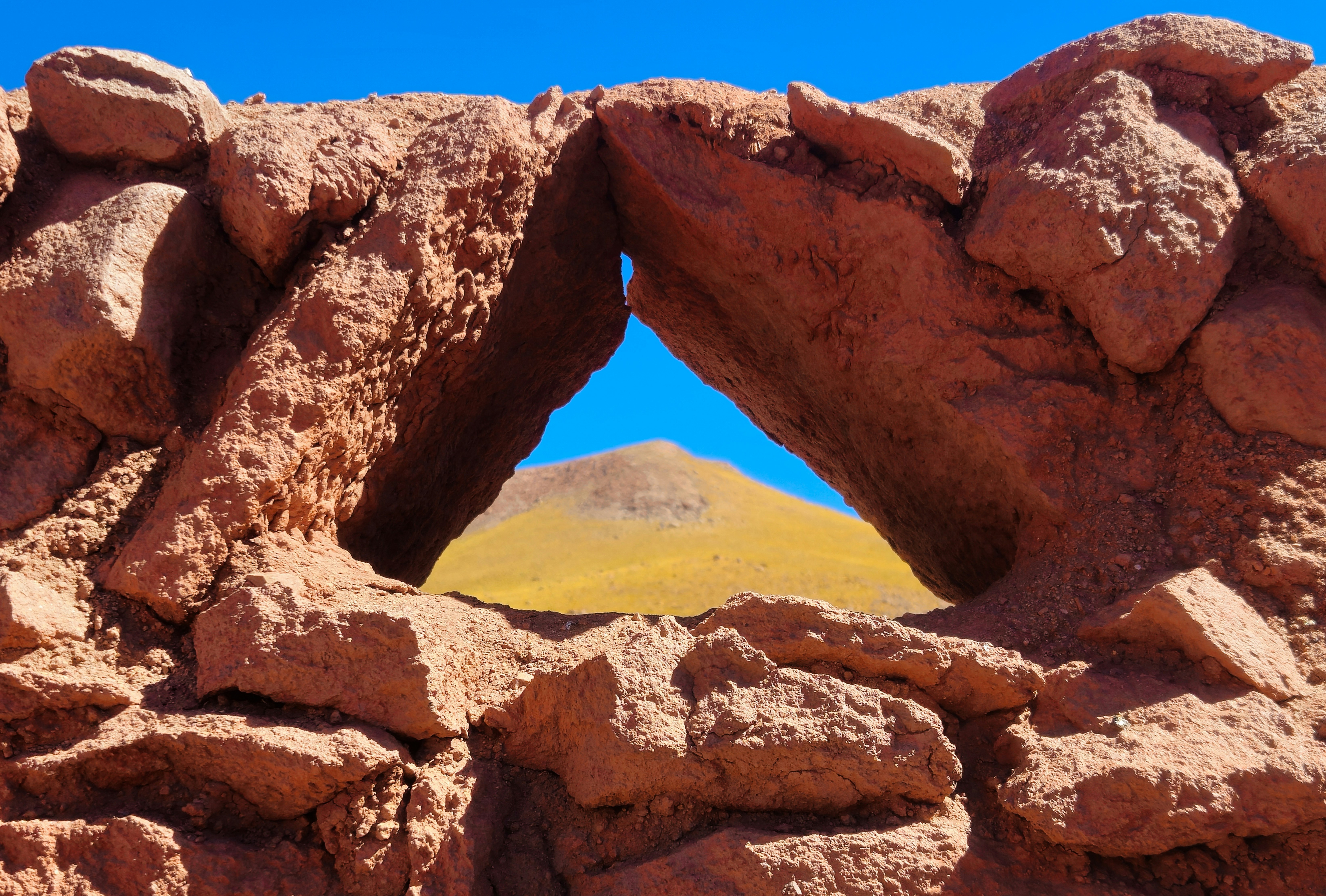 Cleft of Stone: Desert Arch Framed by A distant Hill