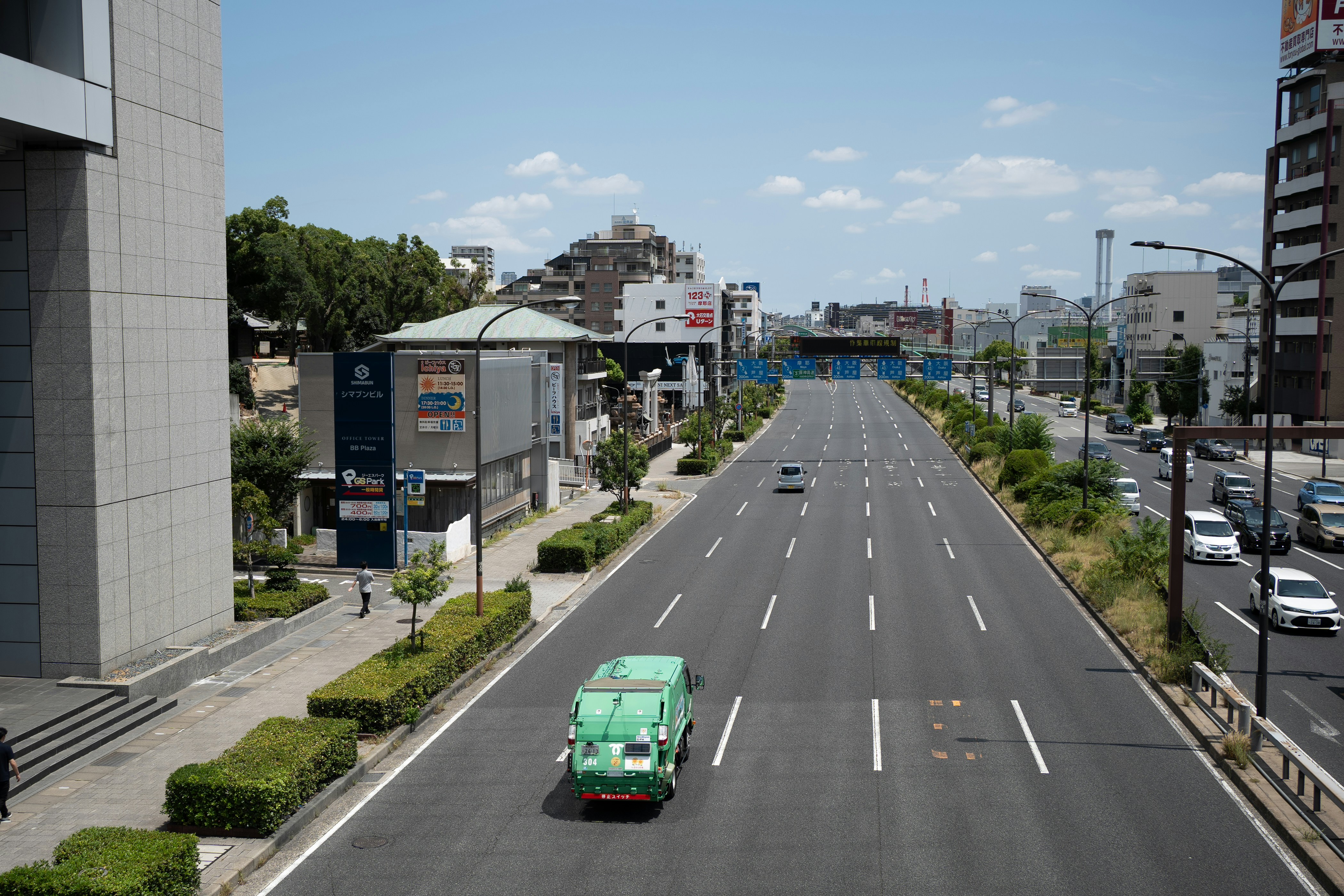 Green vintage van leading the boulevard in an urban arterial