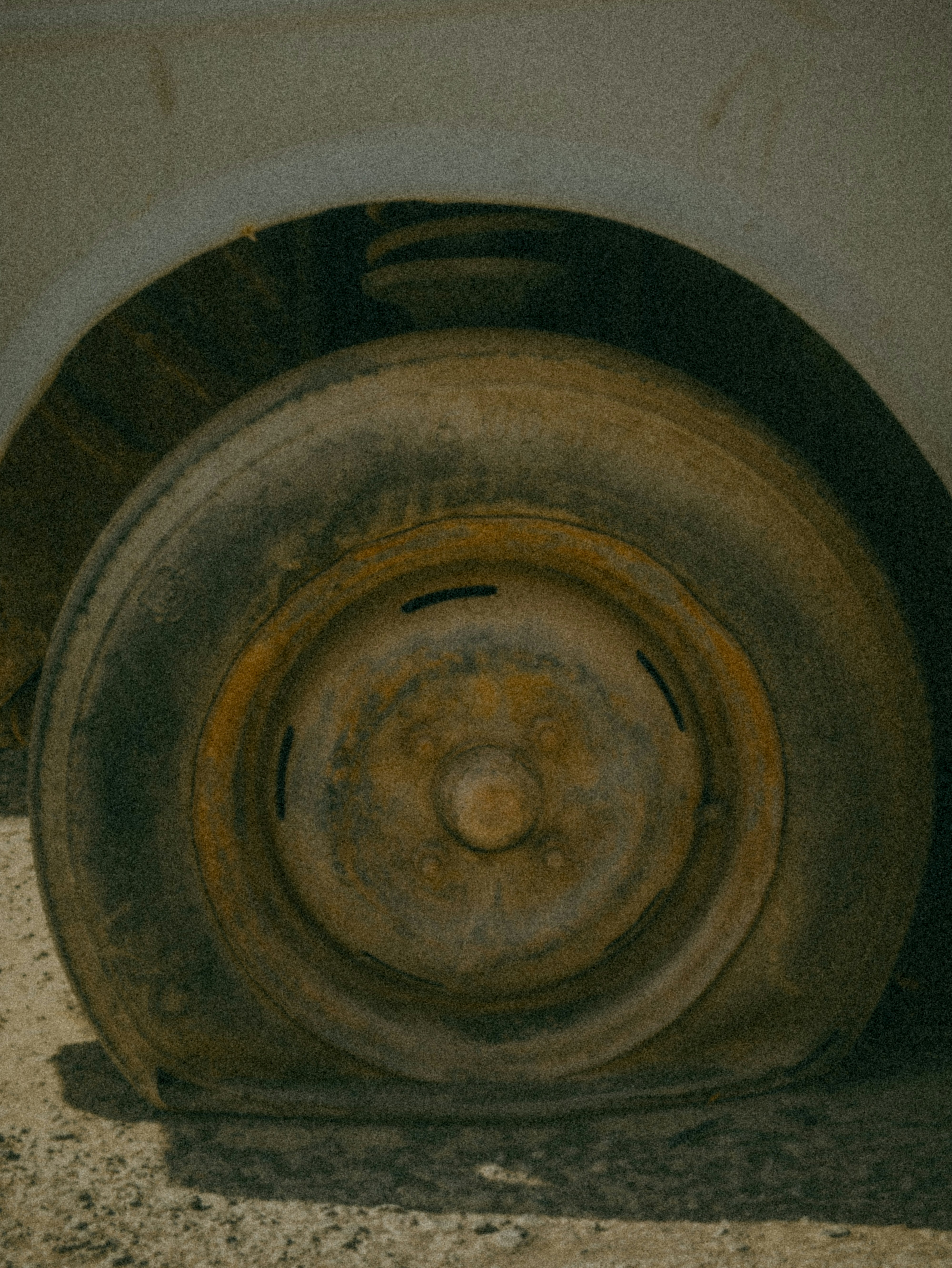 Rusting Wheel Underneath a Weathered Vehicle