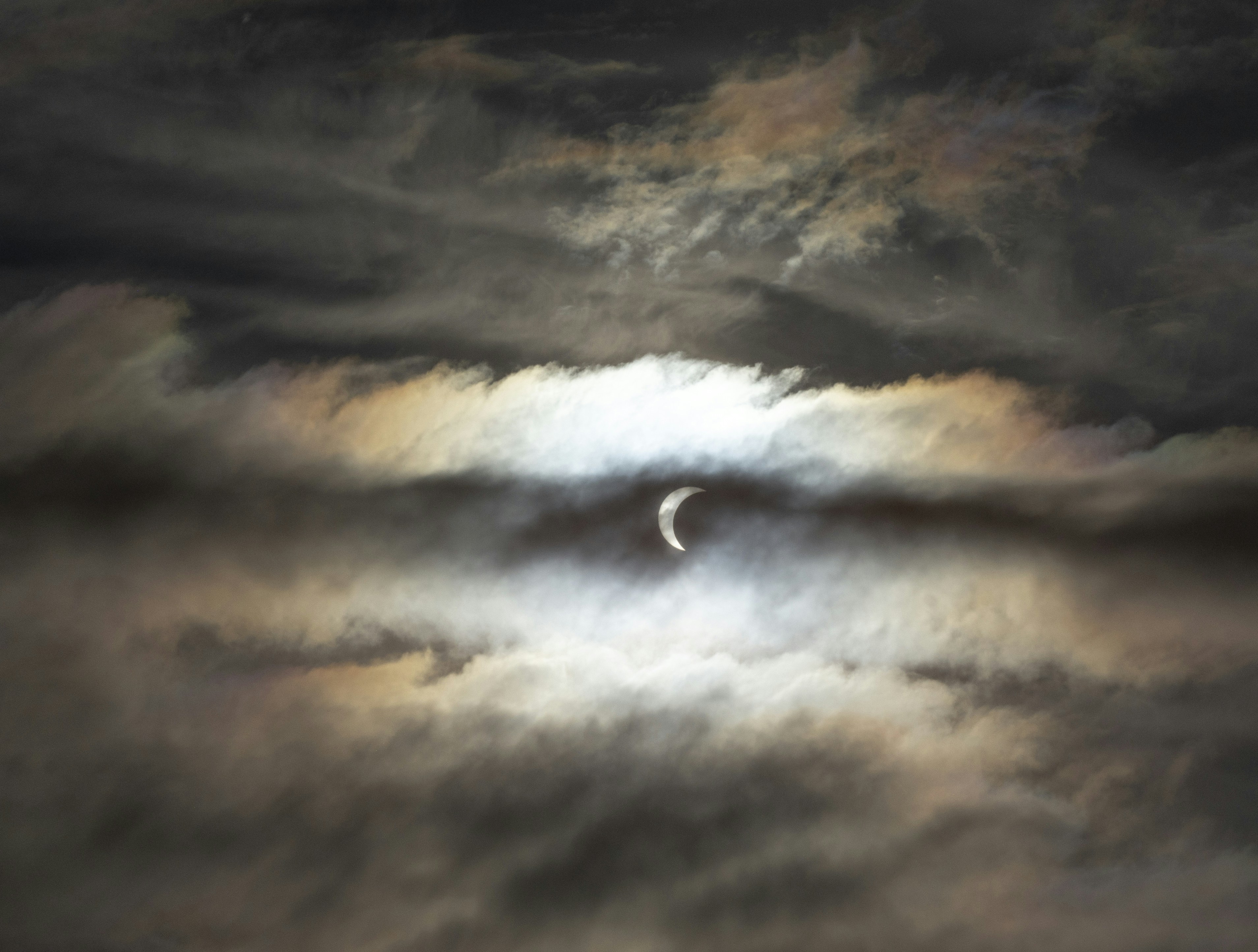 Lunar Veil: A Crescent Quietly Emerges from Smoky Clouds