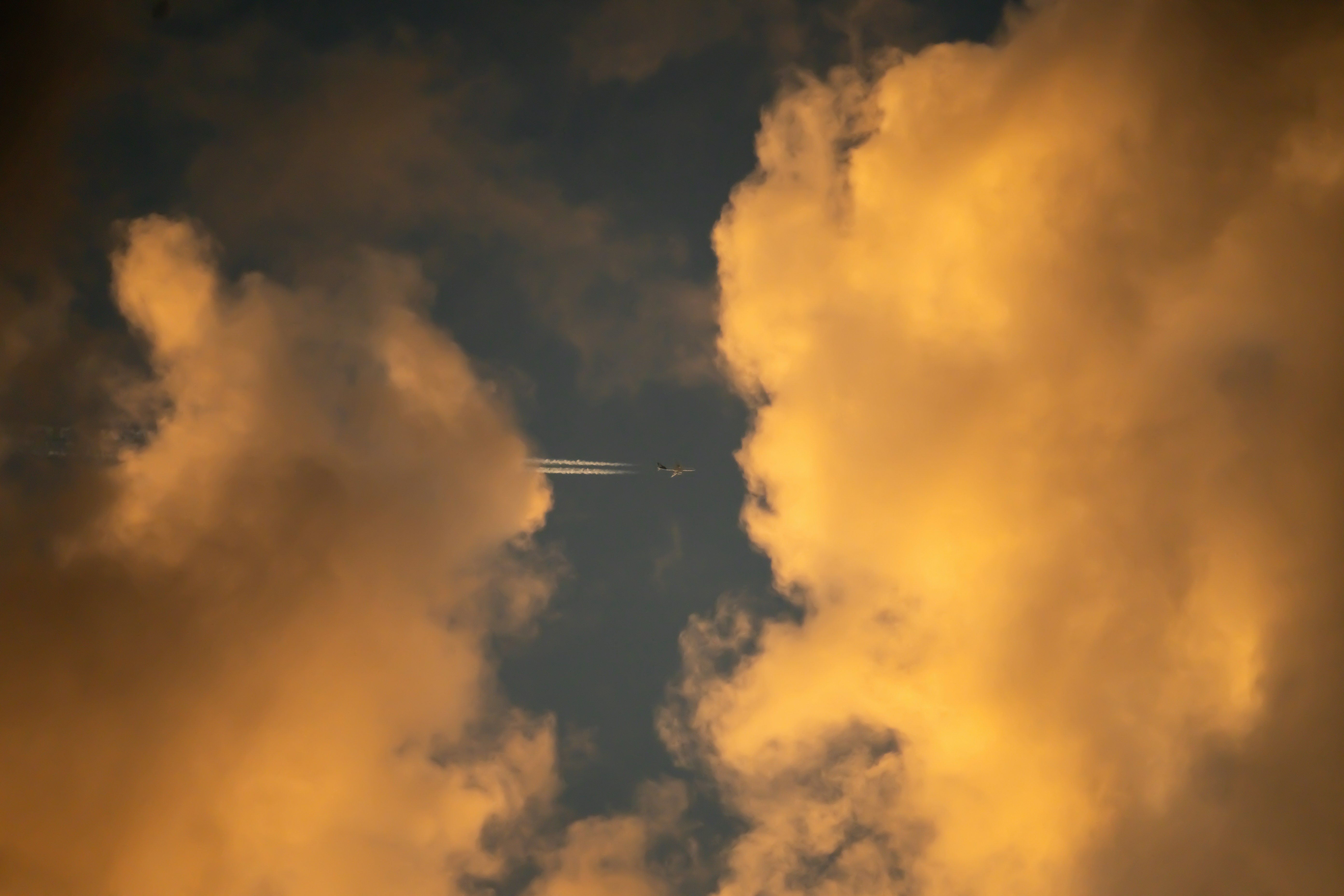 High-Altitude Exit: A Jet Through Sunrise Clouds