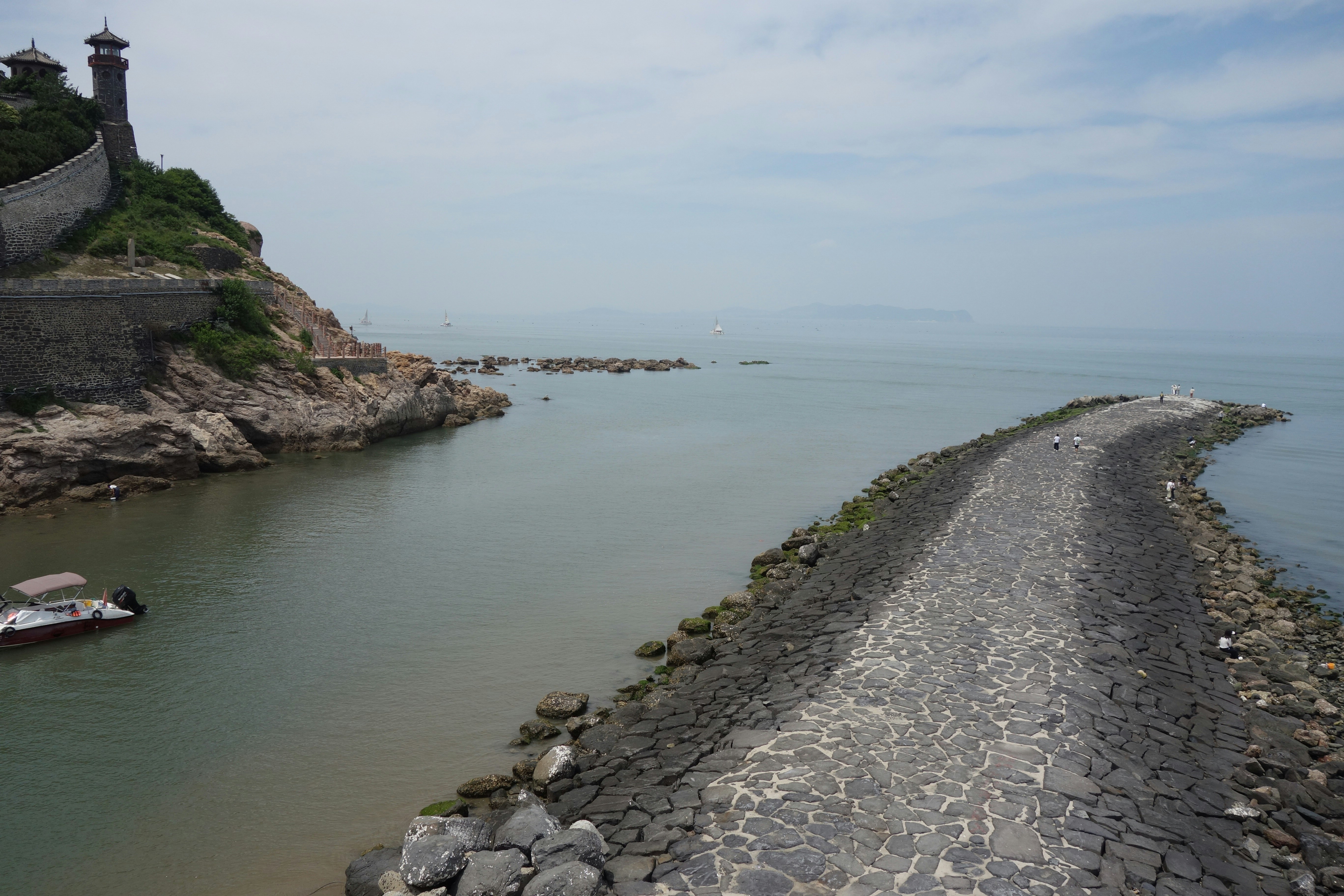 Stone jetty to calm seas: a tranquil coastal path toward distant horizons