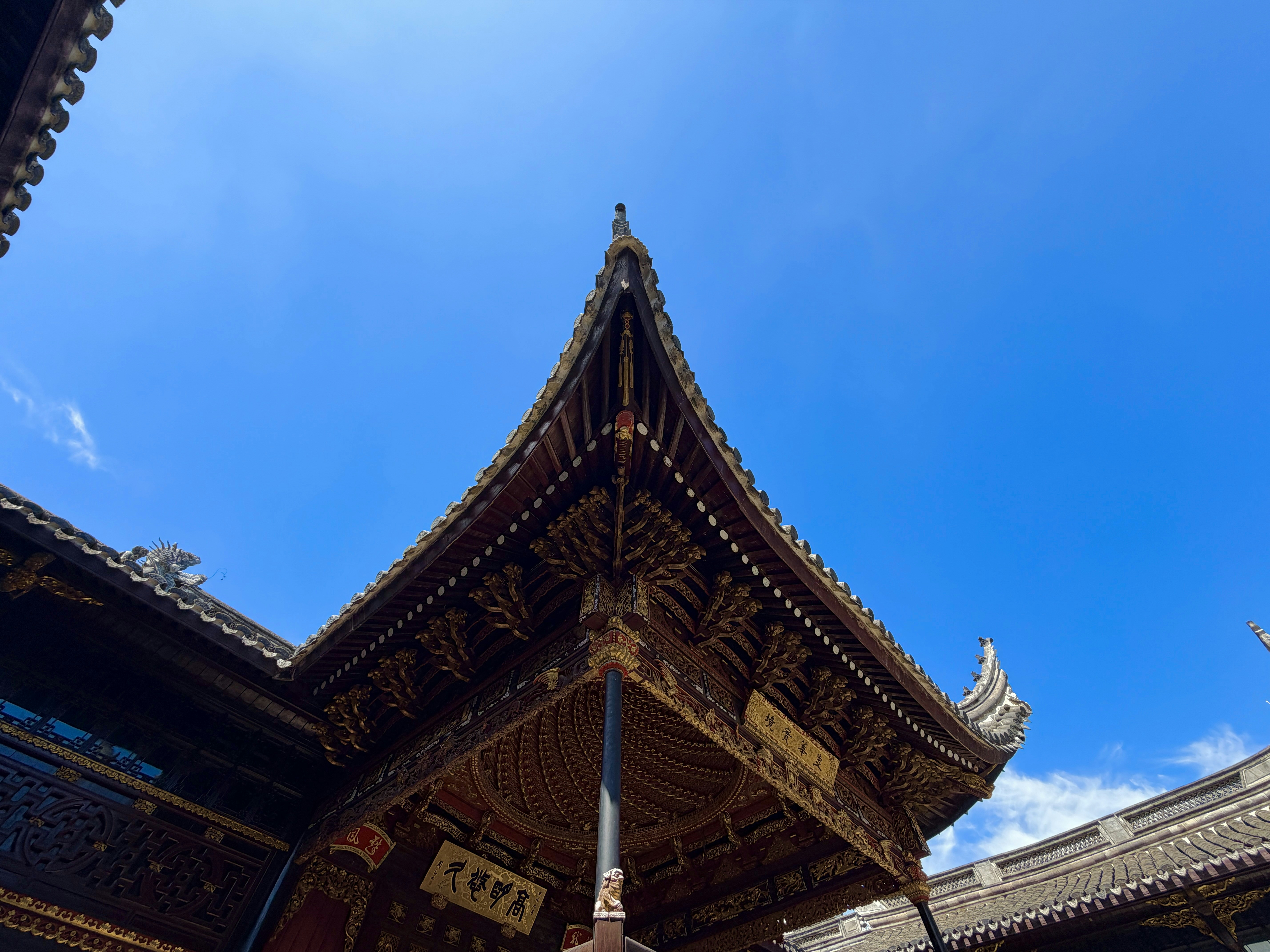 Curved Eaves and Sky: A Sacred Roofline in Sunlit Blue
