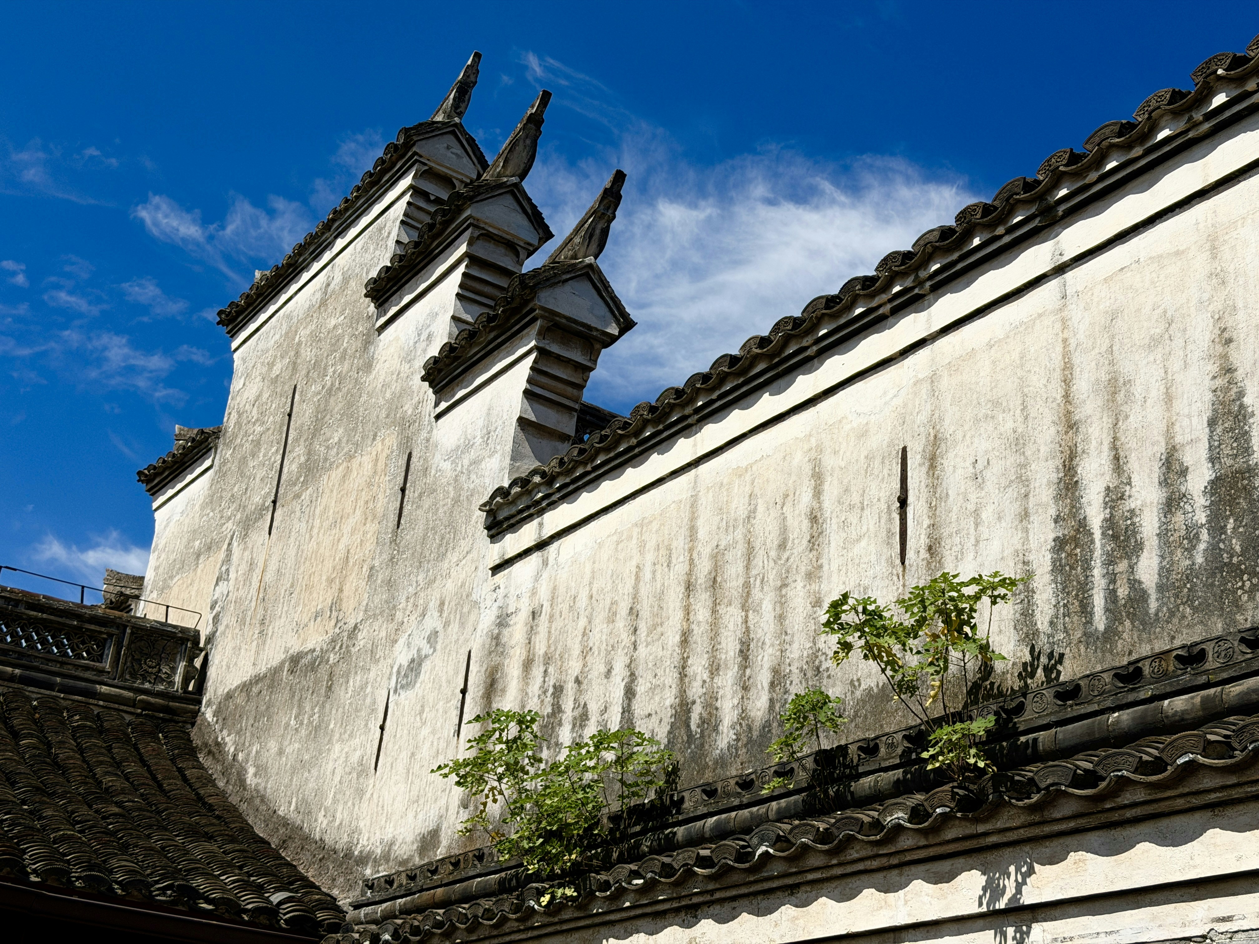 Ruined-white Wall with Unbalanced Rooflines under a Clear Blue Sky