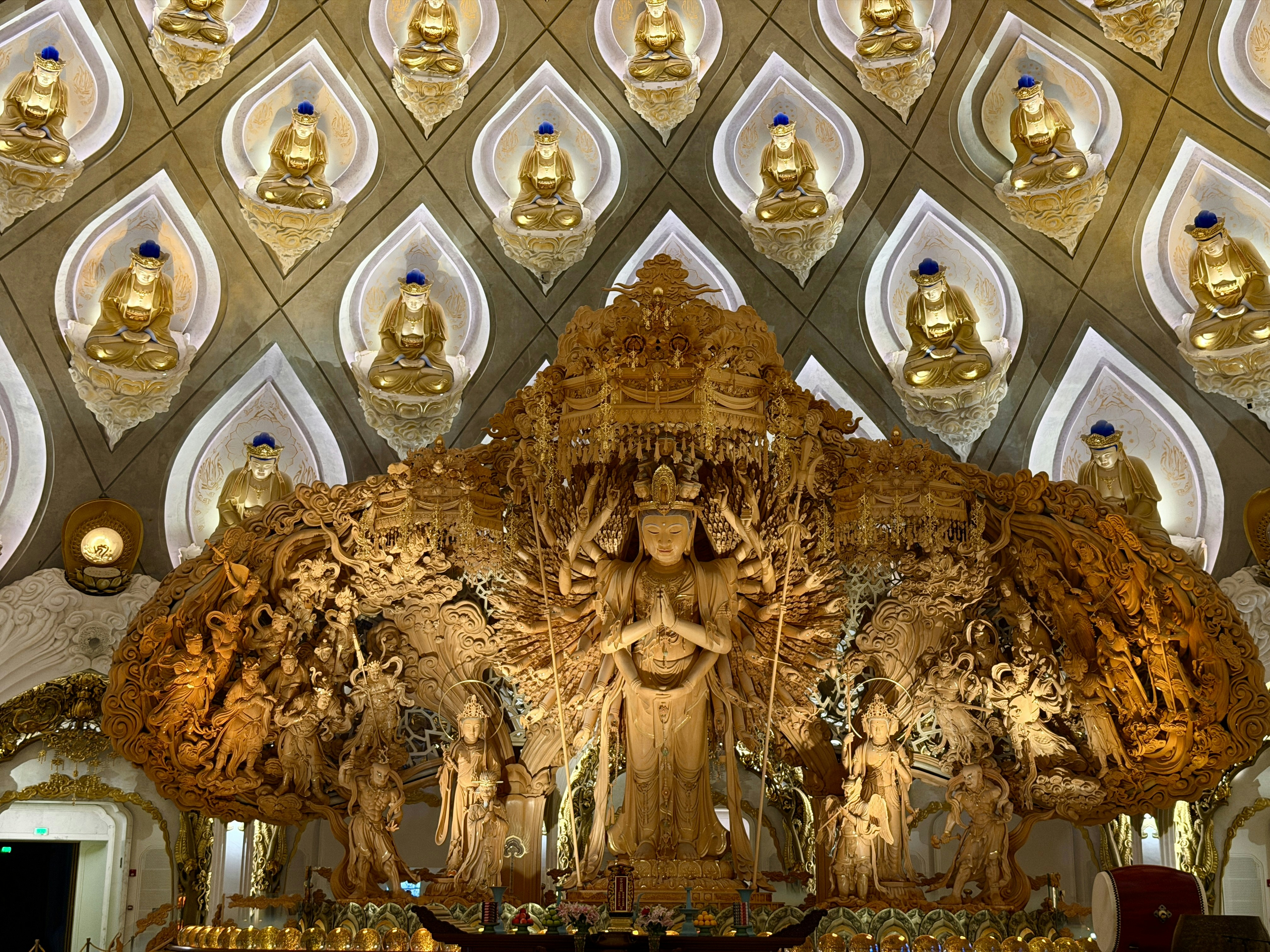 Golden Carving Empire: A Sculpted Choir of Buddhas Within Arched Halos