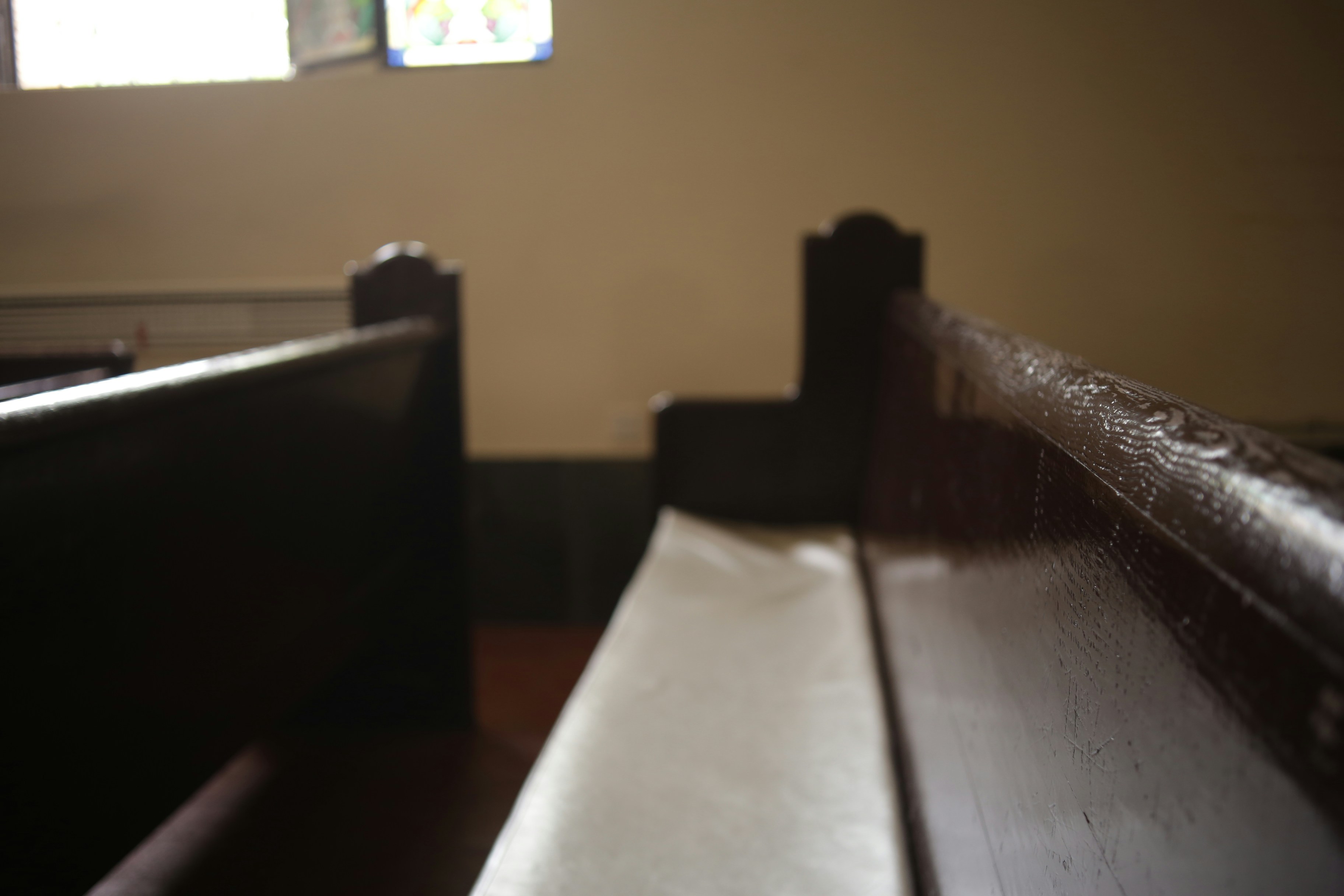 Wooden Pew Leading to a Quiet Aisle