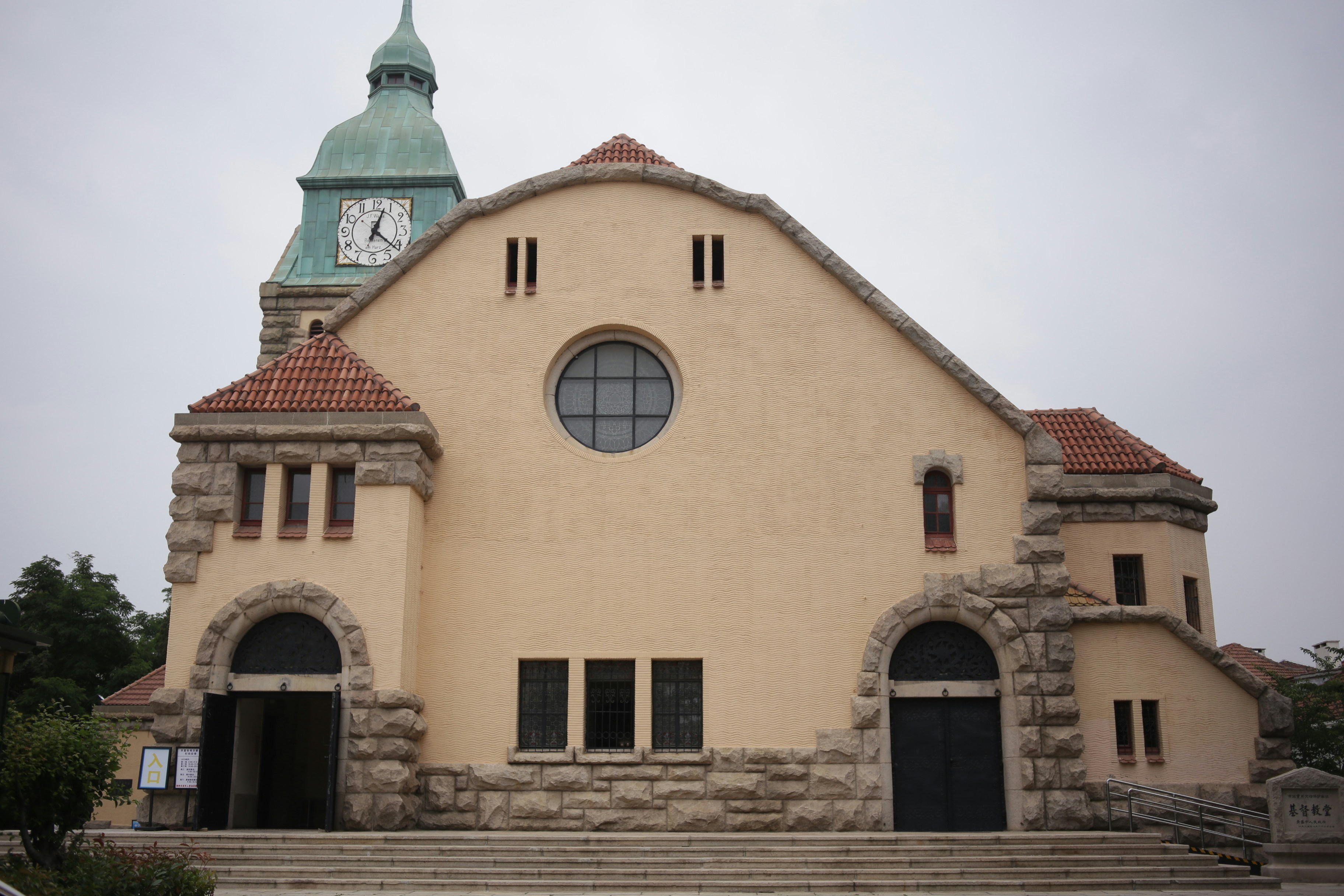 Clock Tower Facade: A Sunlit Church on a Stone-Trimmed Terrace