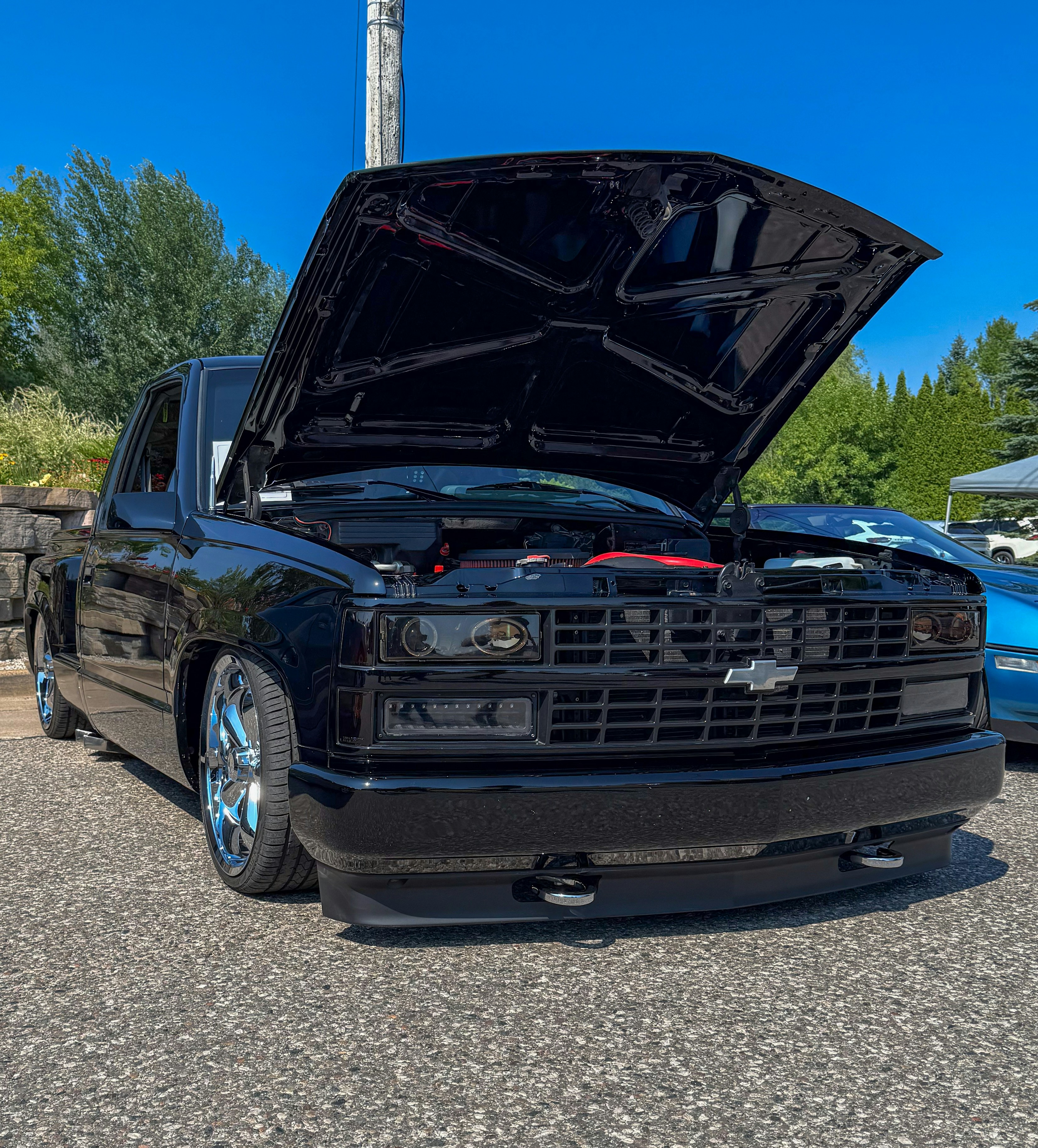 Under the Hood: Black Chevy Pickup with Open Bonnet in Bright Parking Lot