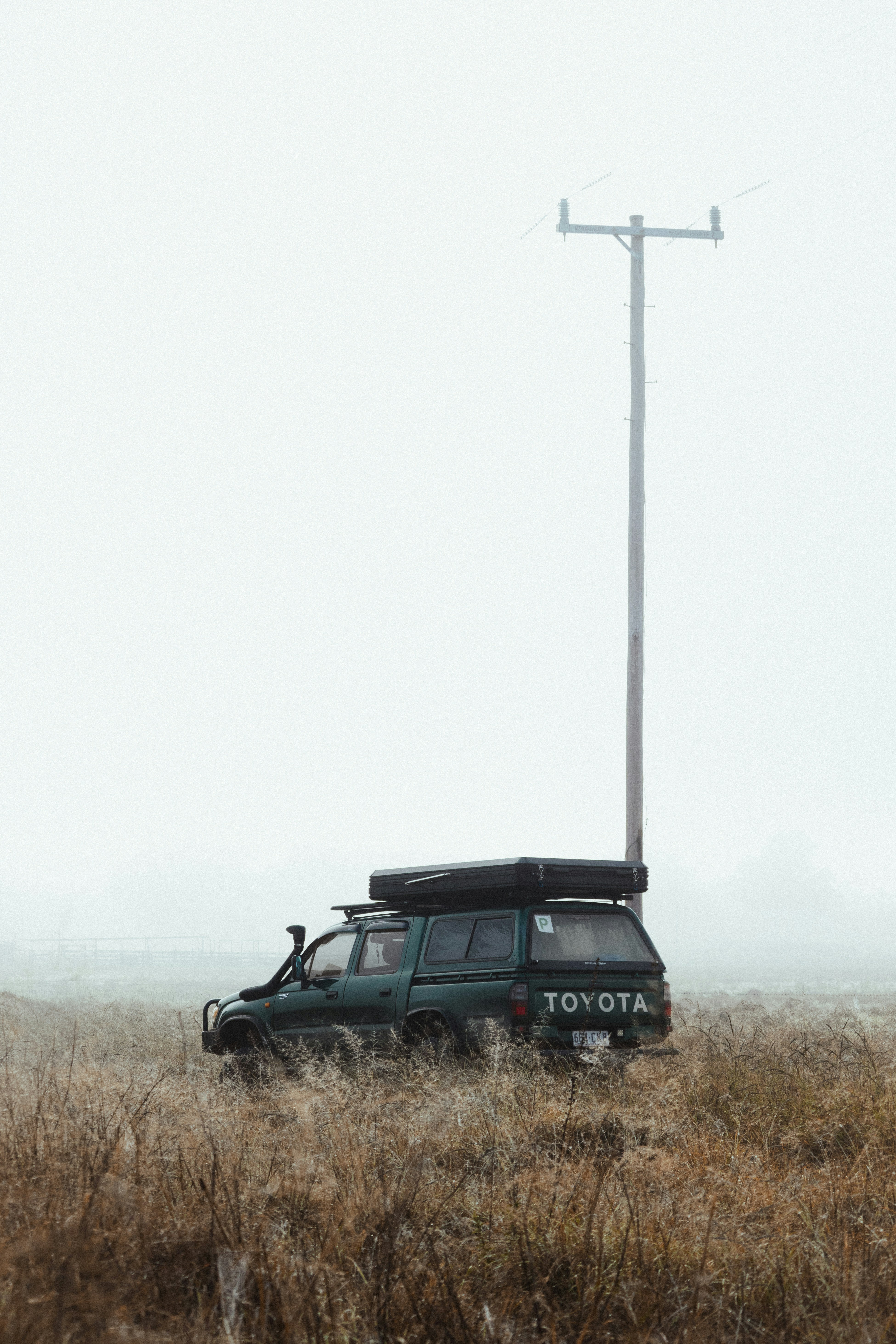 Lonely Lift: A Toyota Camper Under a Distant Powerline