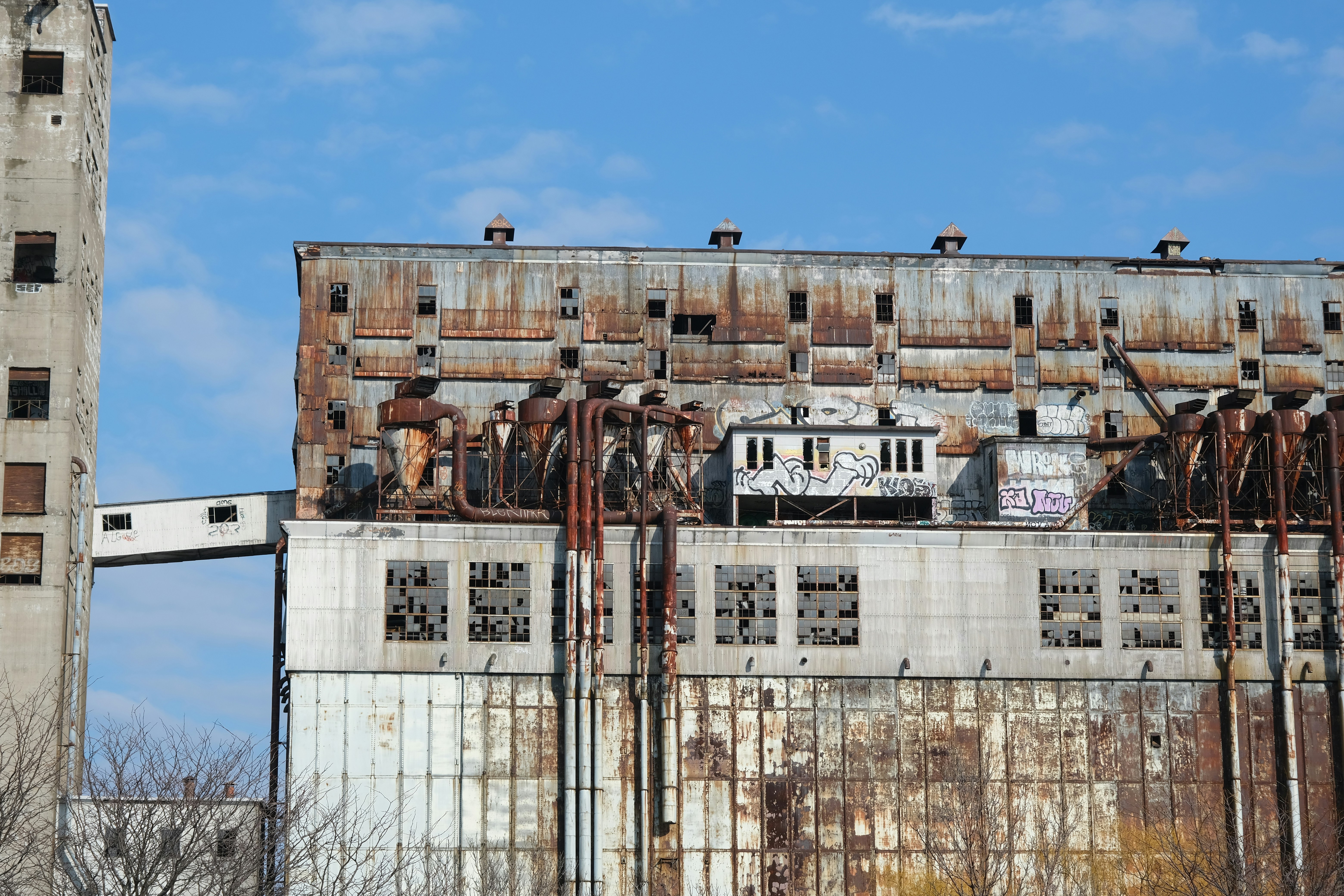 Ruined Factory Facade: Rust, Pipes, and a Worn Sky