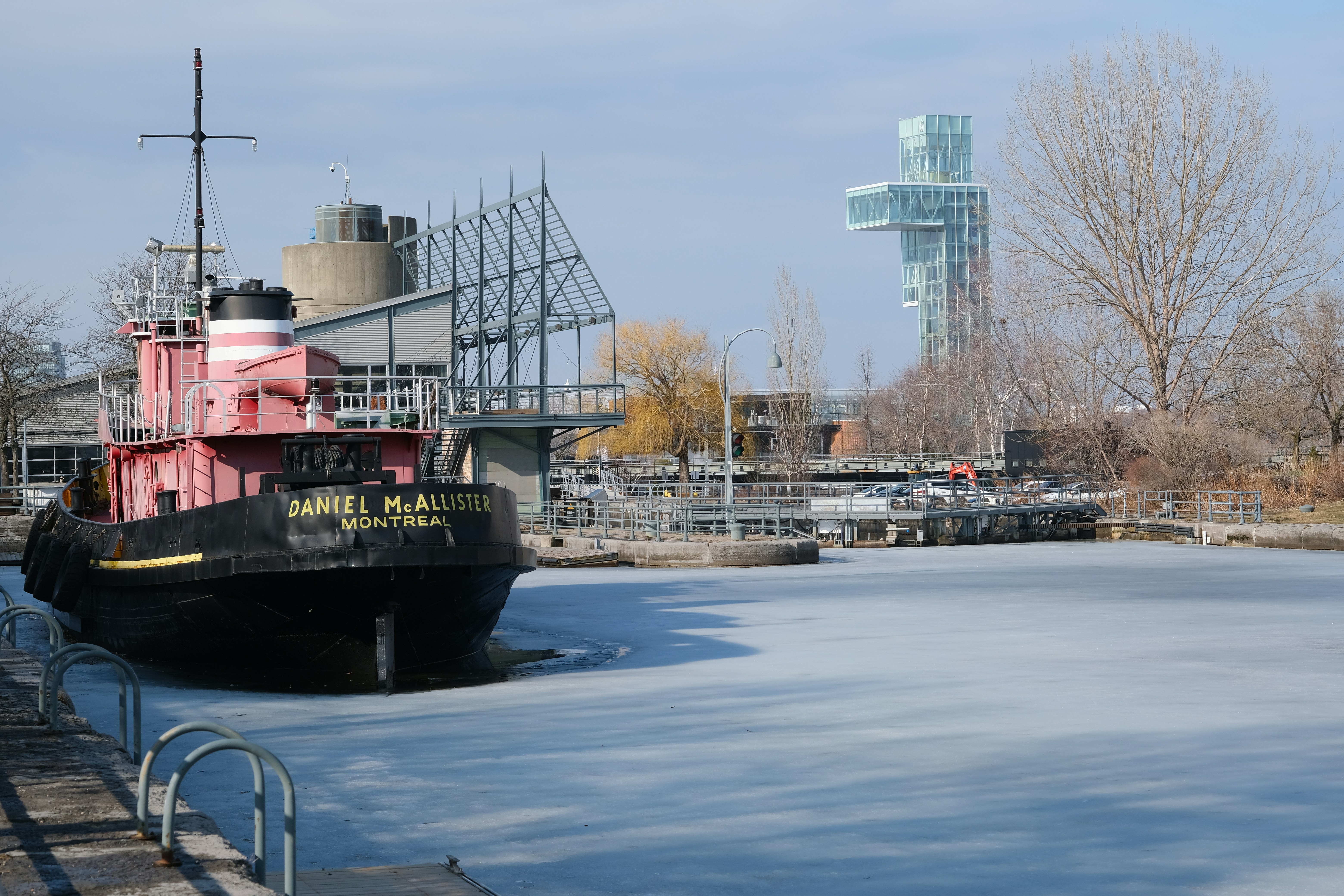 Barge at the Waterfront: Ice-kissed River with Modern Turreted Structure