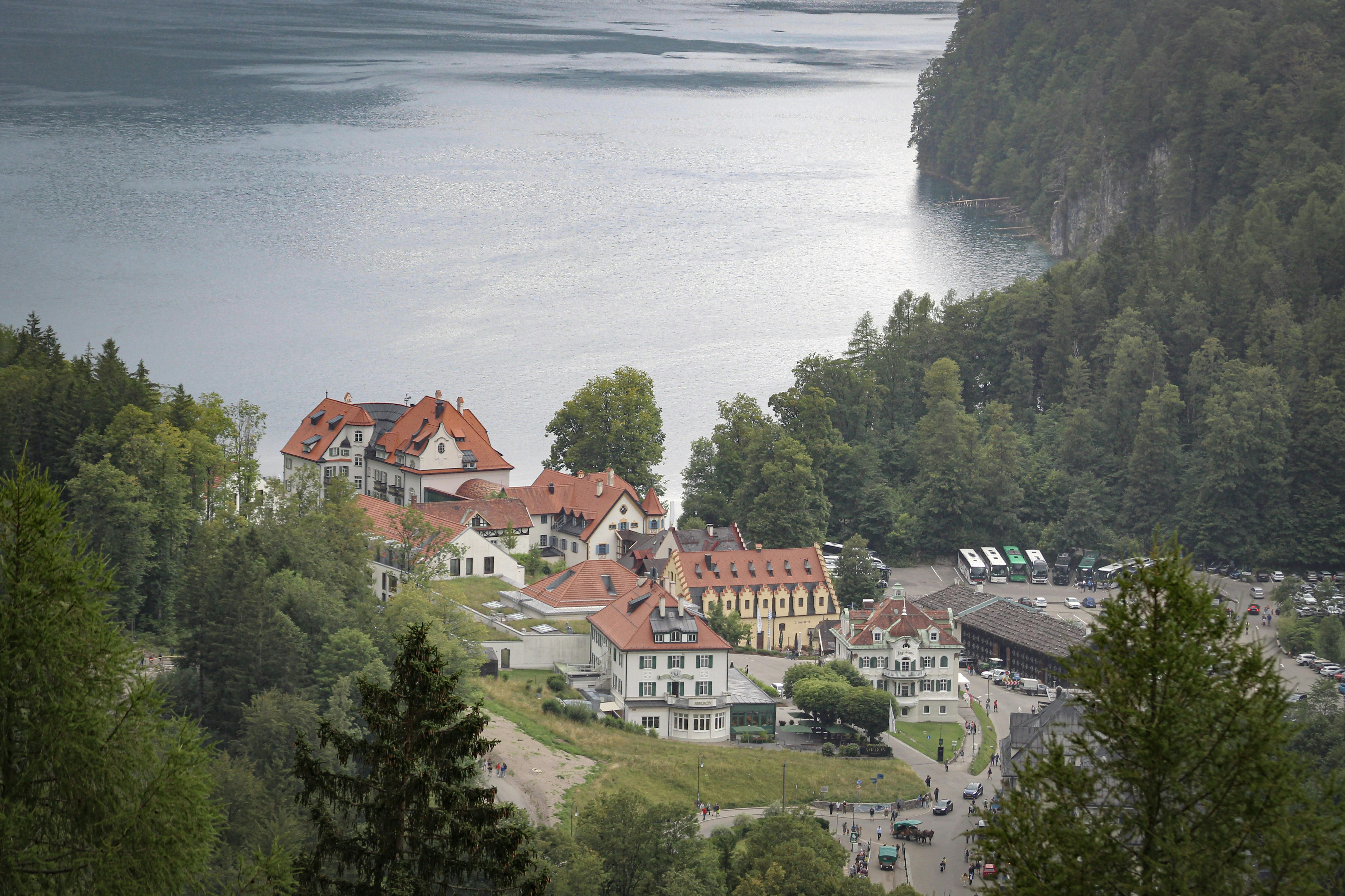 A village clustered at the lakeshore beneath a forested hillside