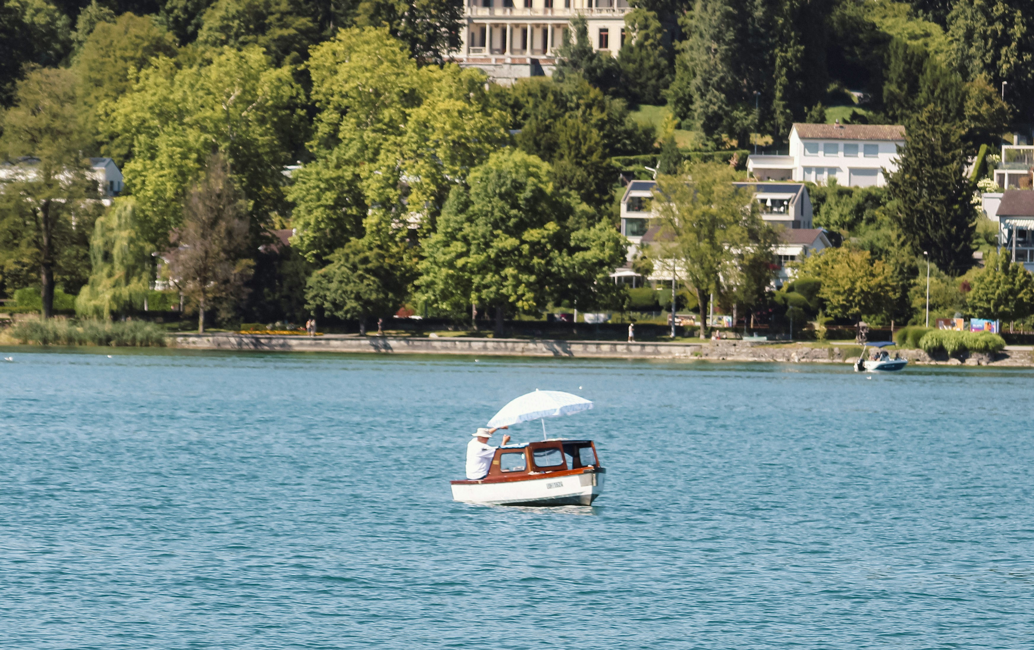 Sunlit Boat Drifting Across a Quiet Lake
