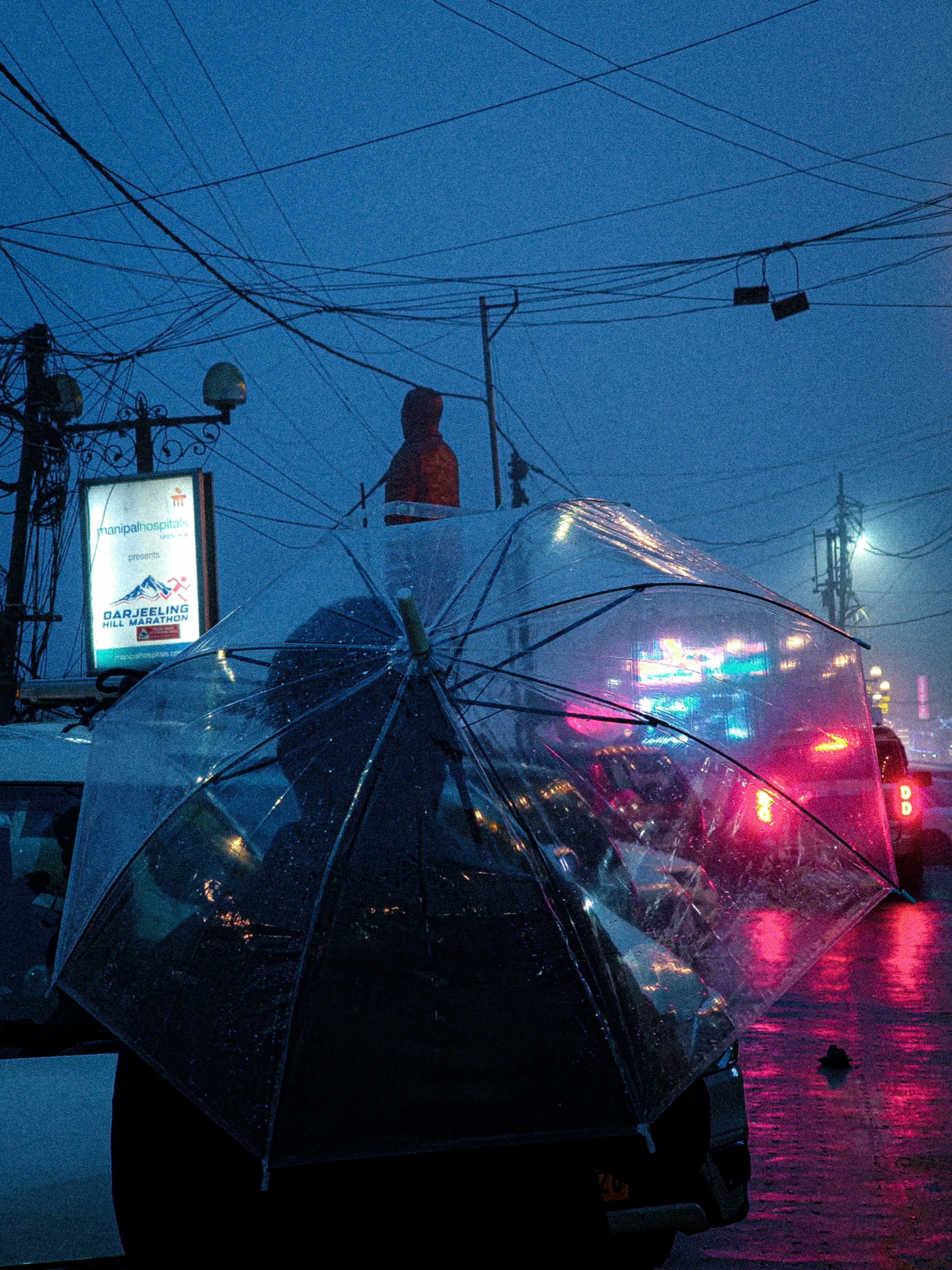 Neon Reflections Under Rain: Transparent Umbrellas in the City Night
