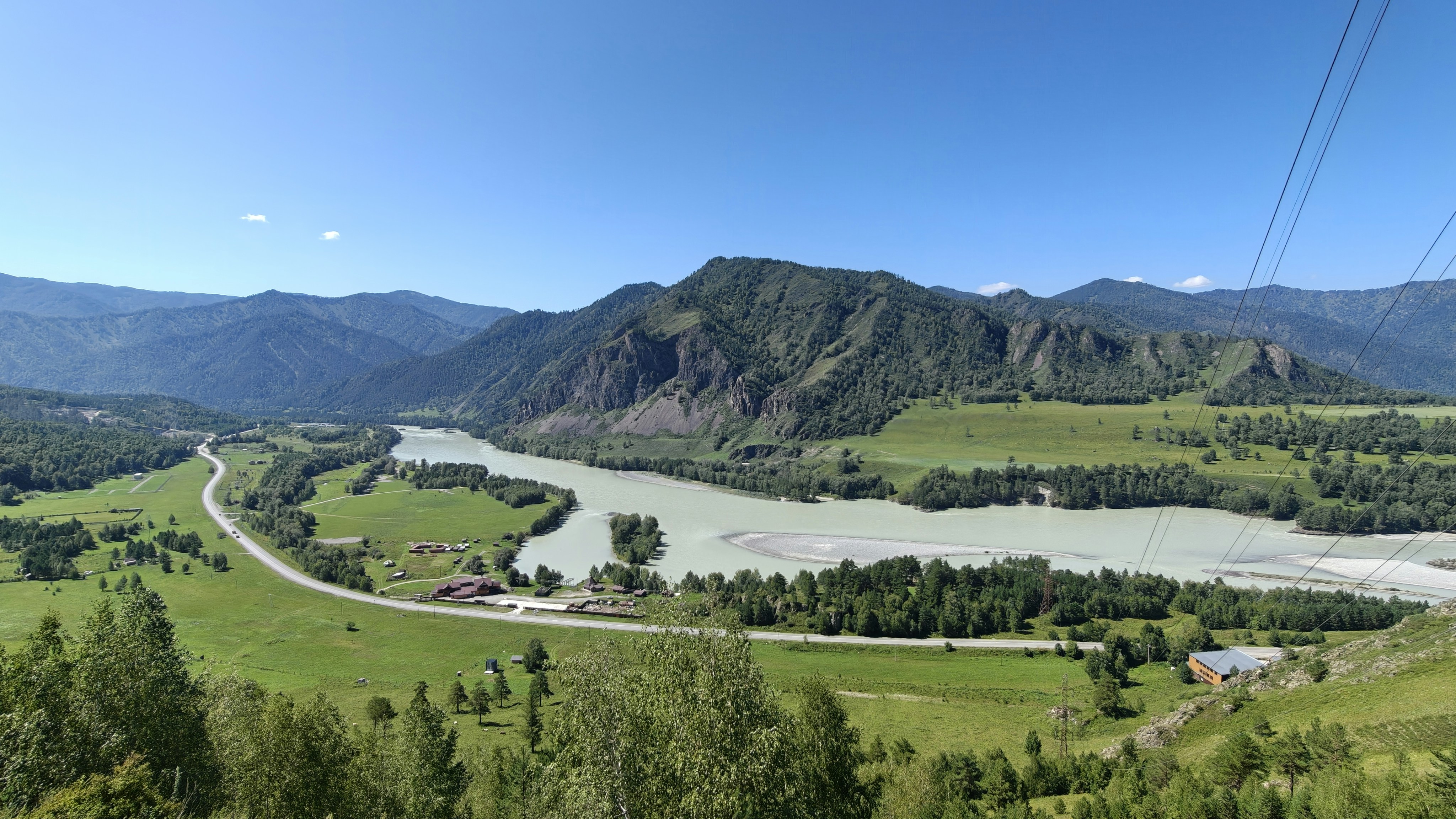 Vale of Rivers and Ridges: A Farmland Panorama Under Blue Skies